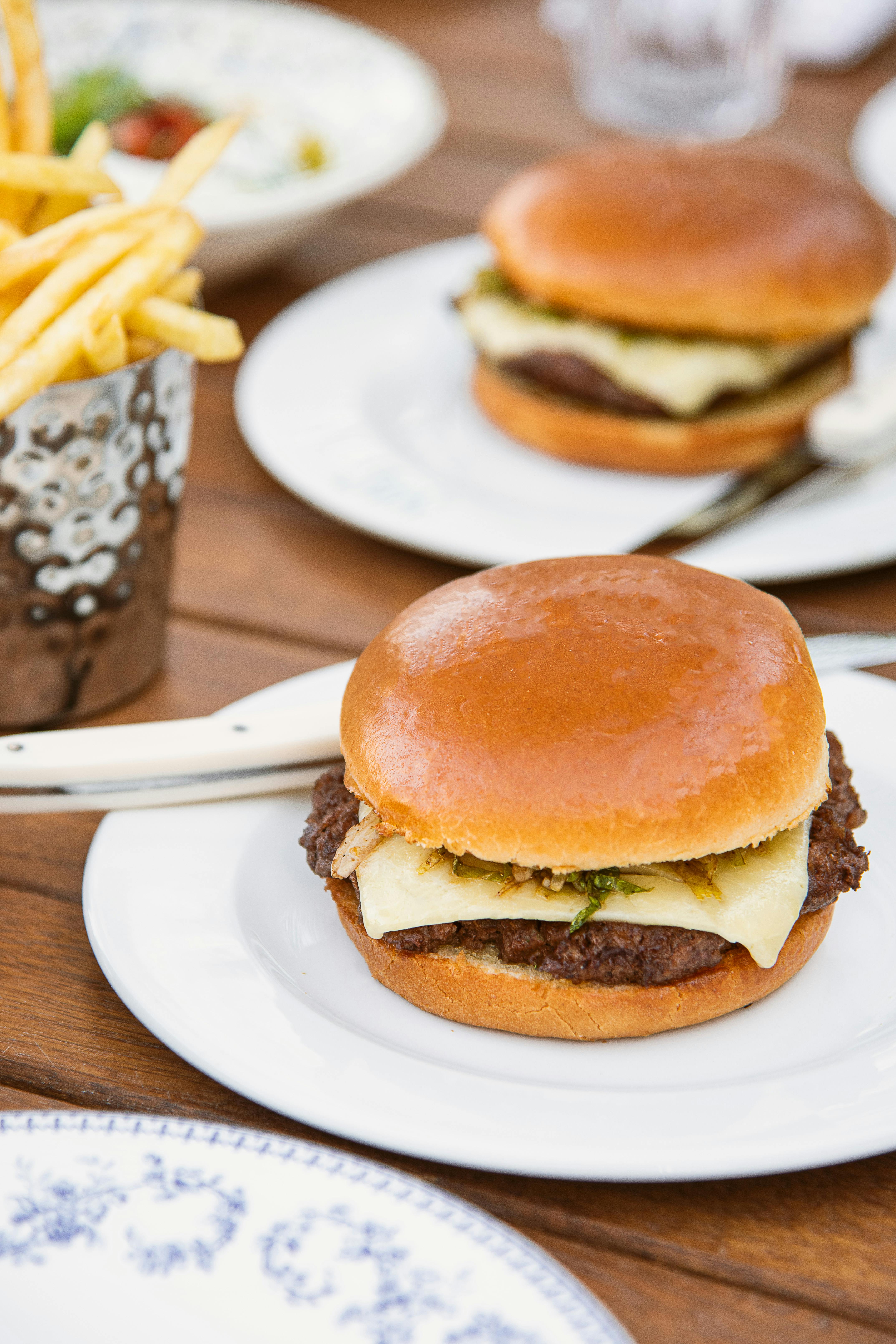 Photo of a Cheeseburger Near a Magazine · Free Stock Photo