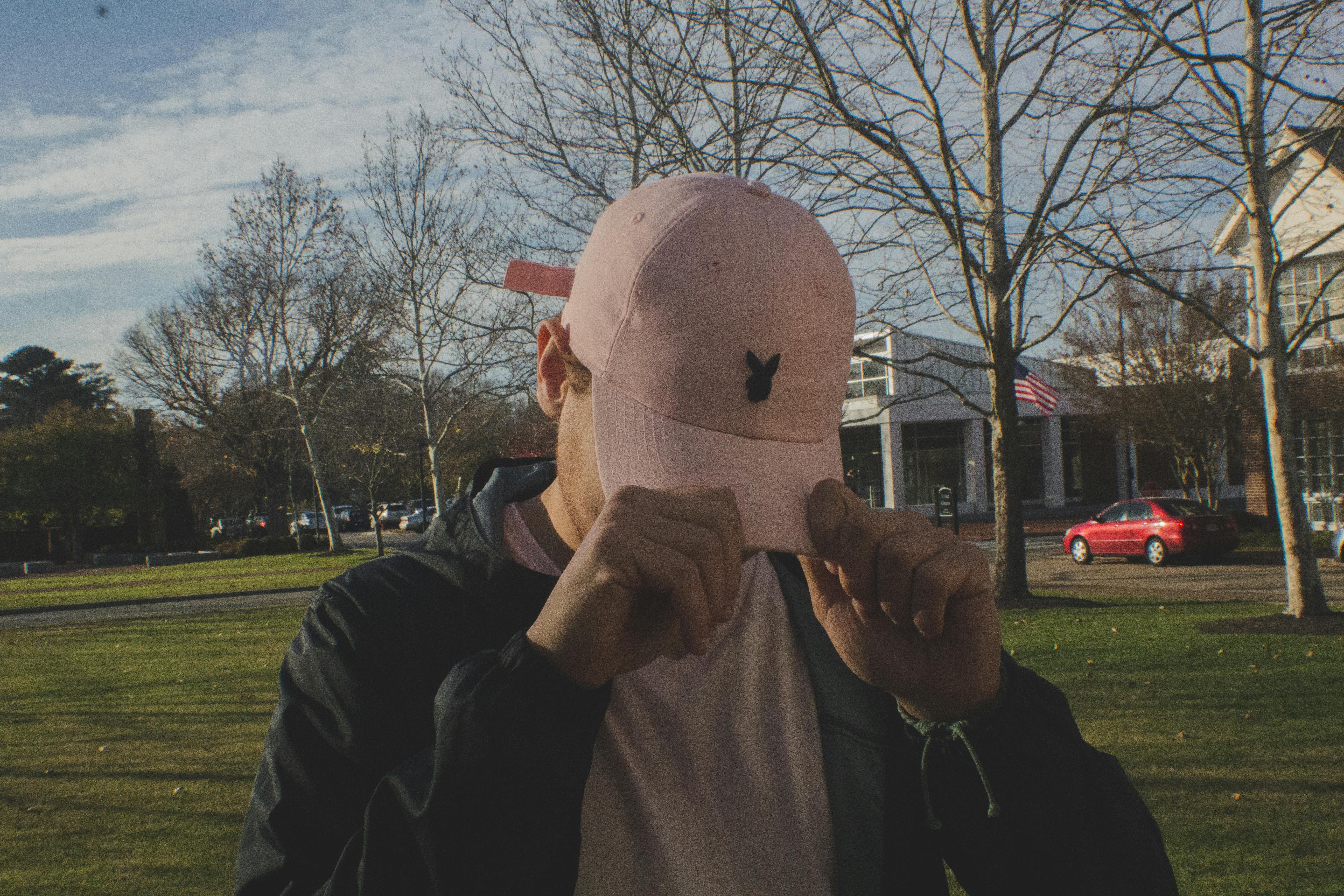 Man Holding White Bunny Fitted Cap · Free Stock Photo
