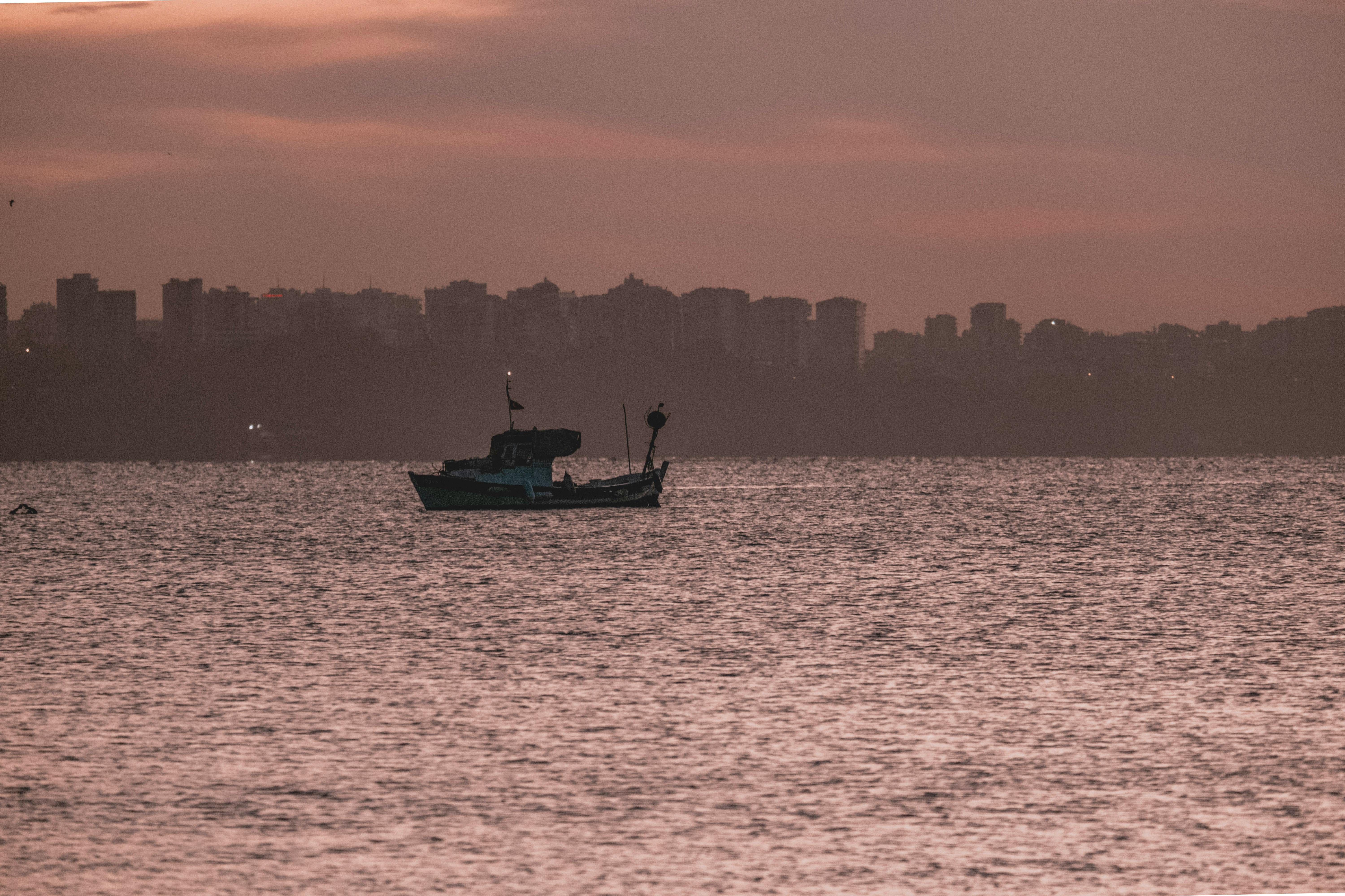 Boat Sailing in the Ocean Near the City Buildings · Free Stock Photo