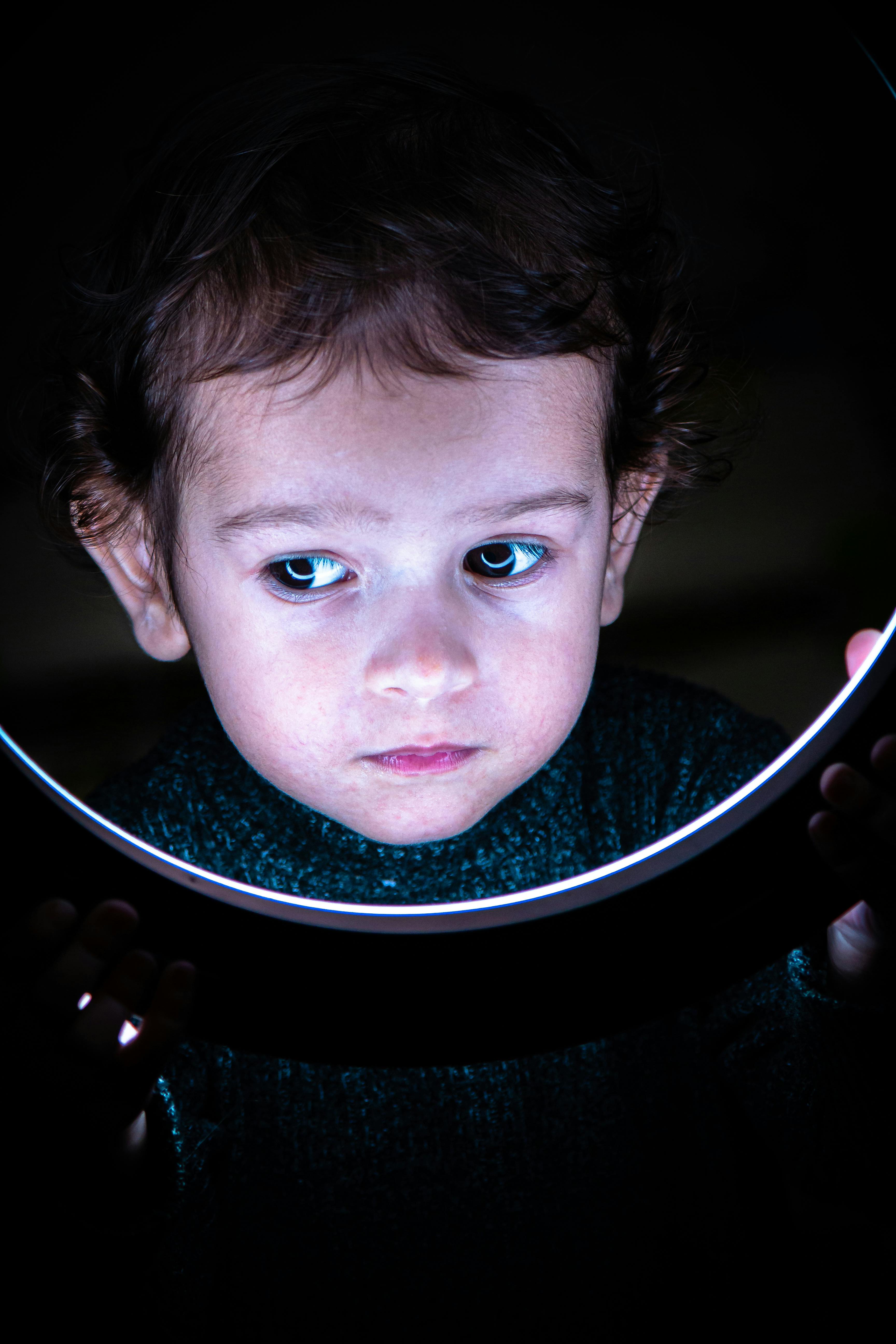 A Cute Little Kid Standing Behind a Ring Light · Free Stock Photo