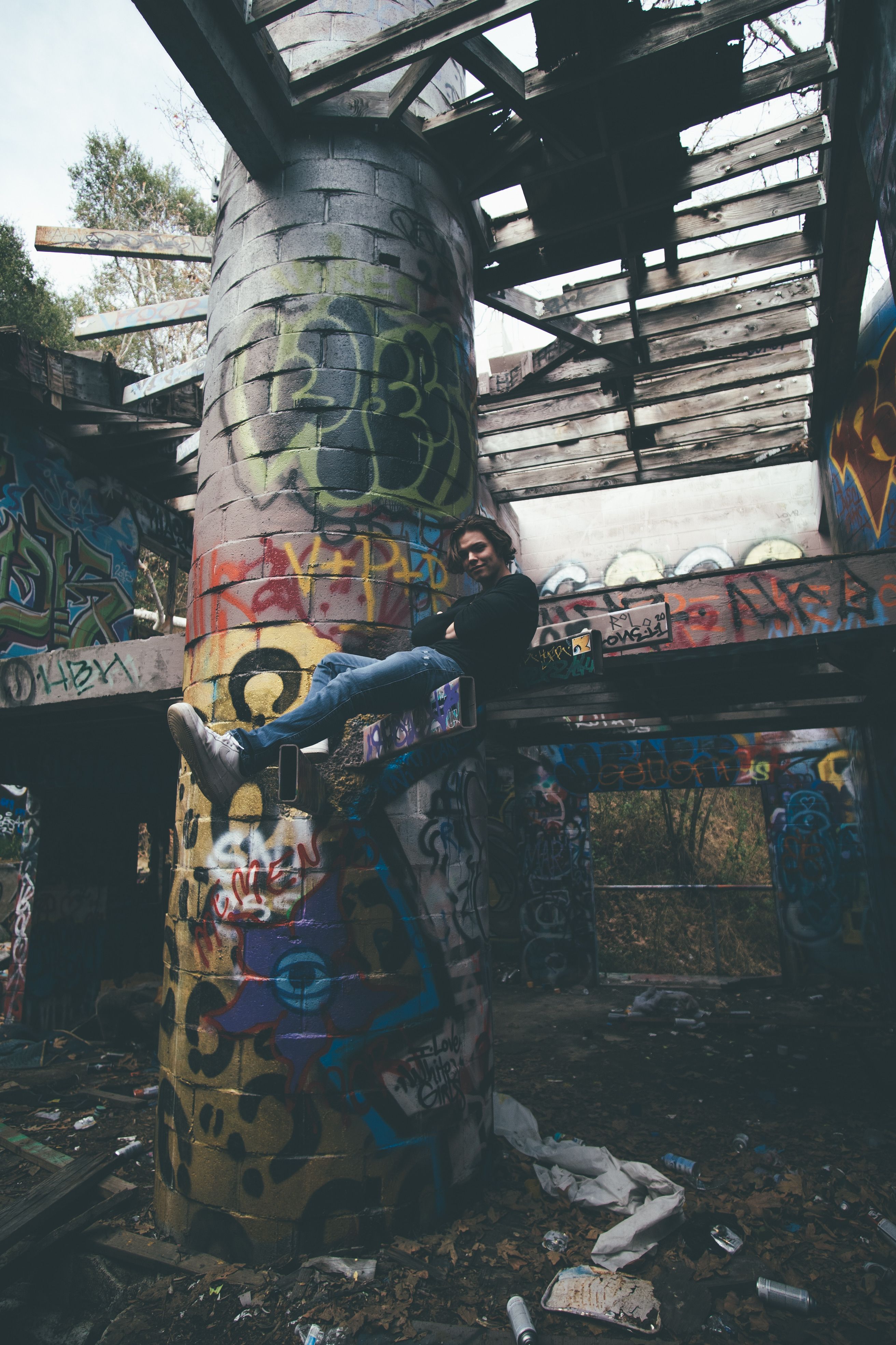 Man Sitting among Walls with Graffiti · Free Stock Photo
