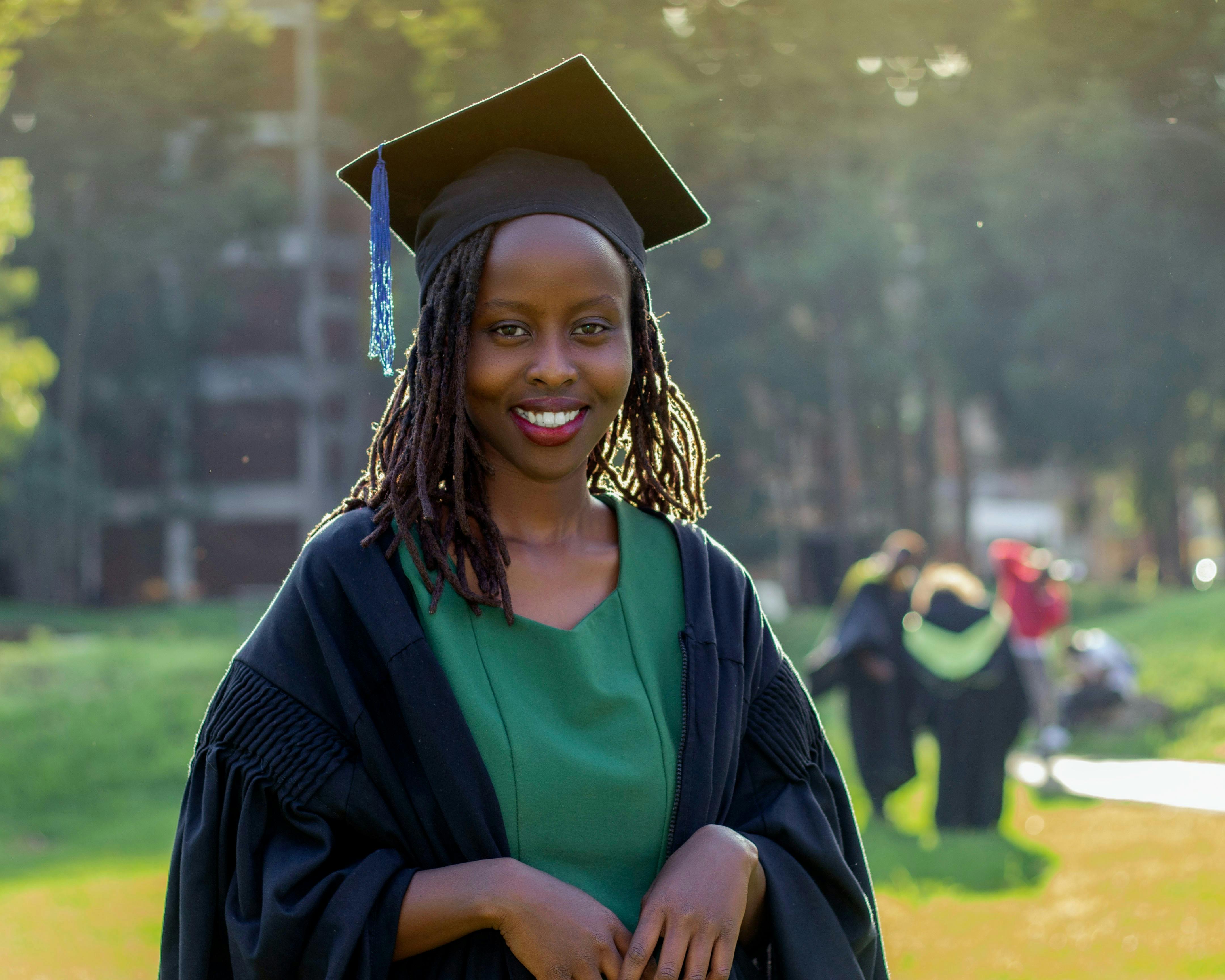 Woman Wearing Black Graduation Coat Sits on Stairs · Free Stock Photo