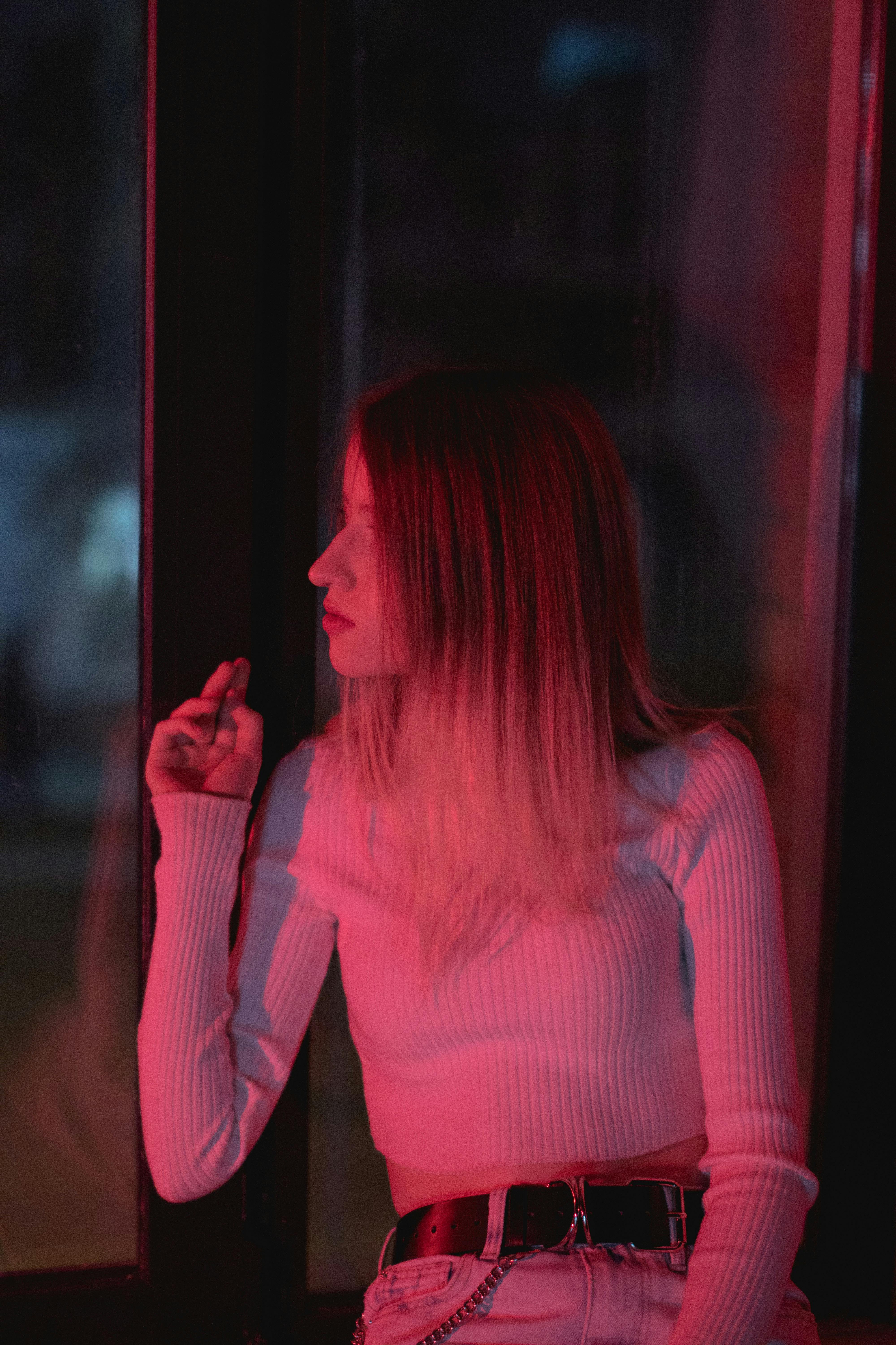 Woman Sitting by Window under Red Light · Free Stock Photo
