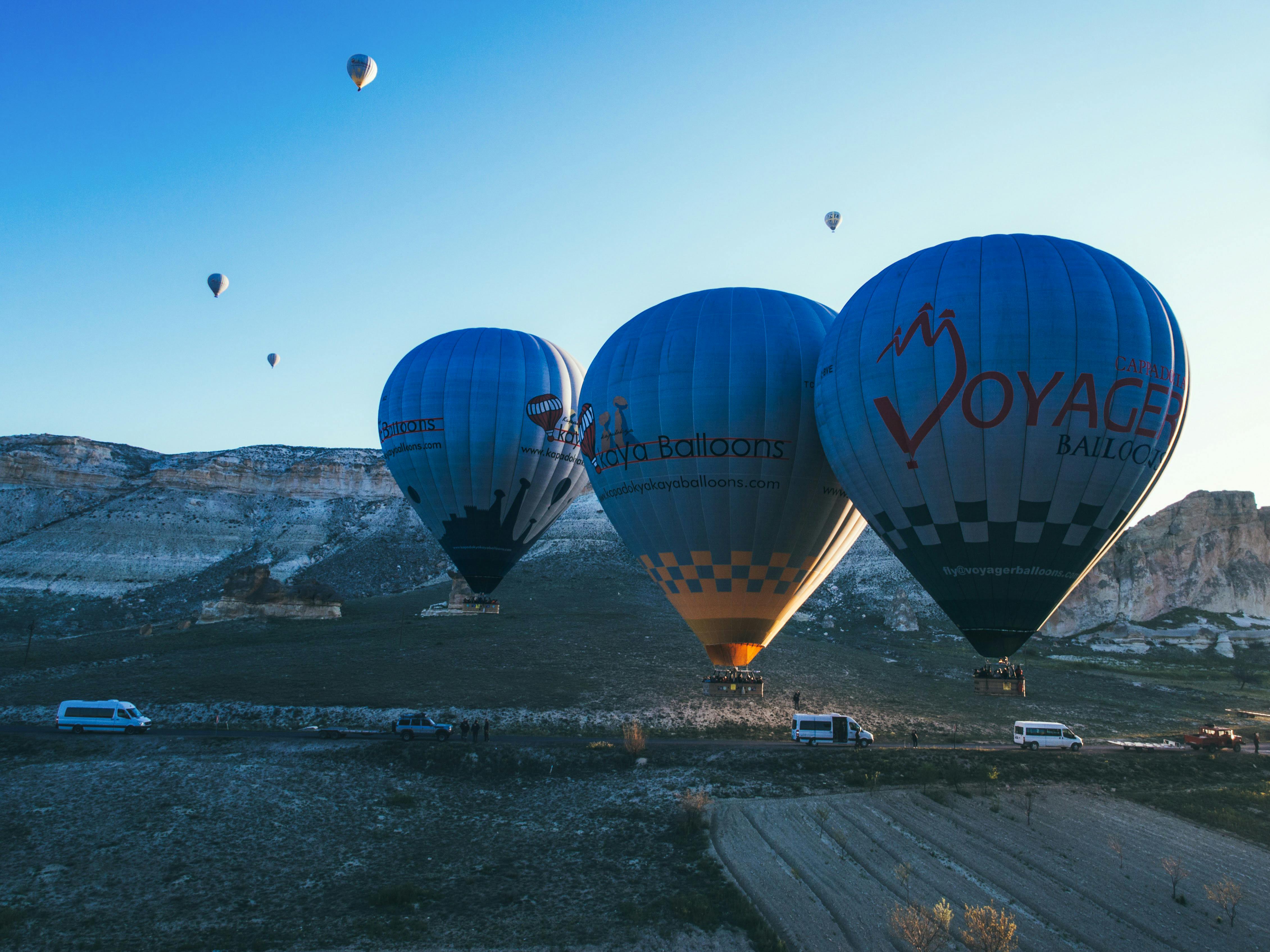 Hot Air Balloons Flying over Mountainous Landscape · Free Stock Photo
