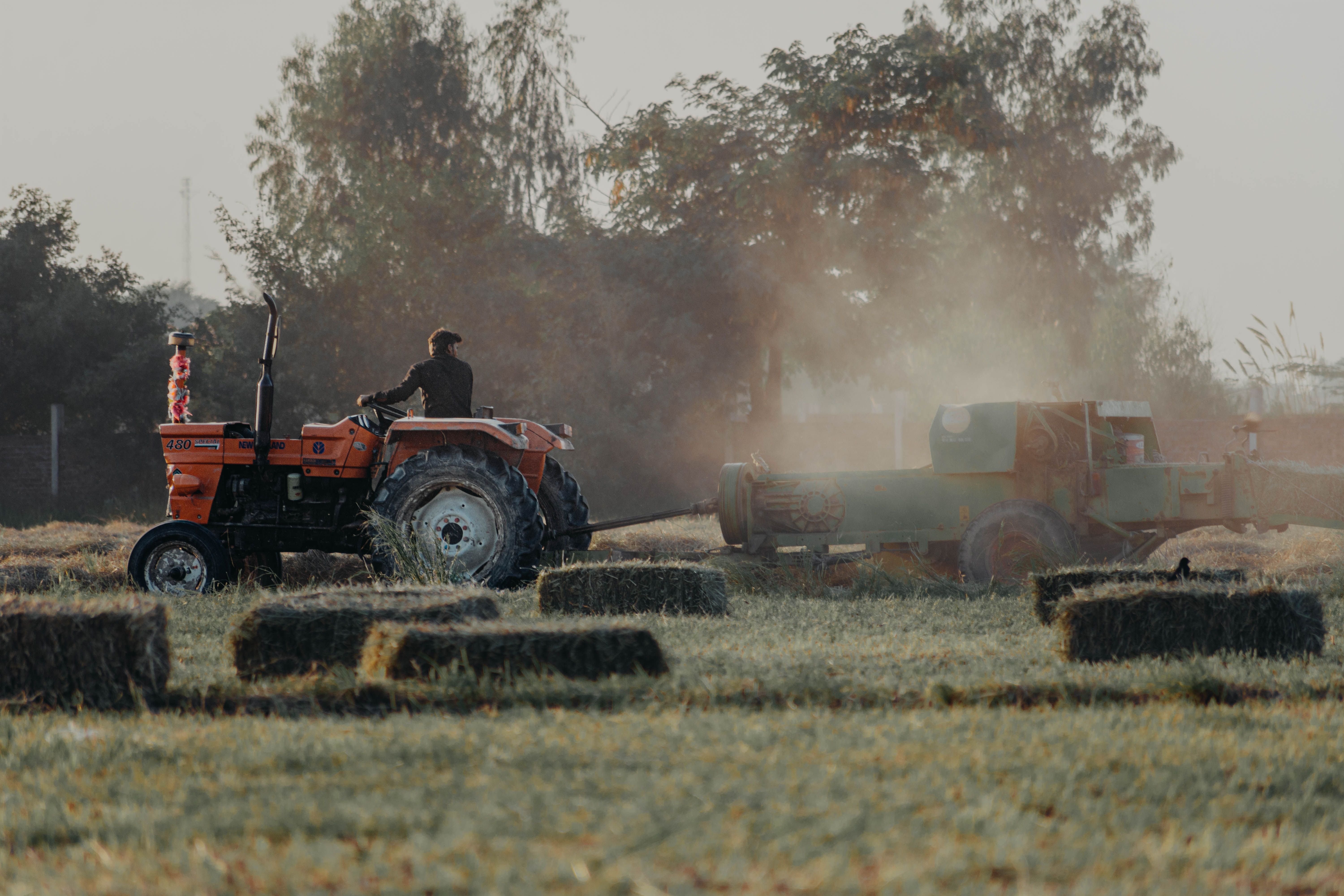 Man Working with Tractor on Field · Free Stock Photo