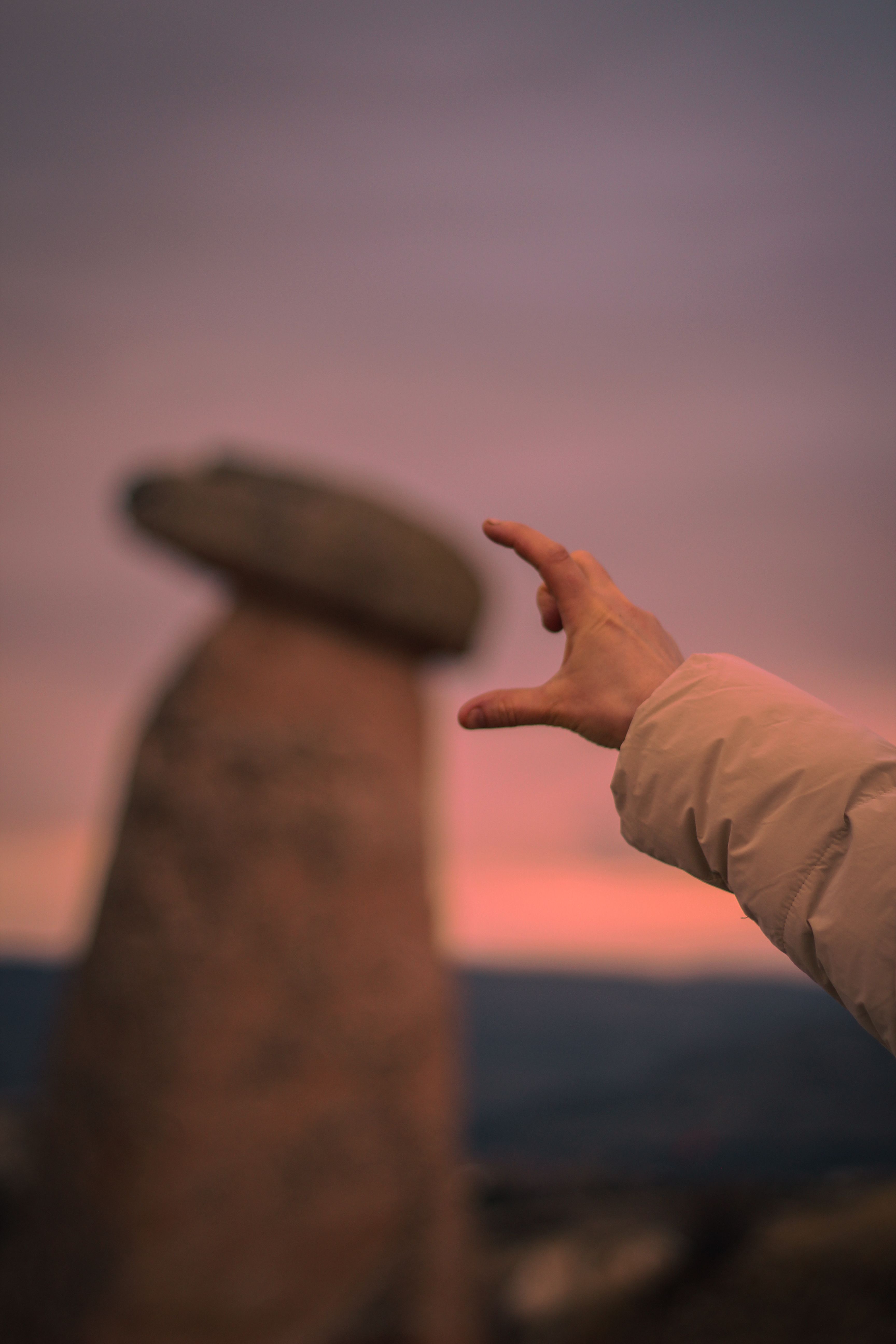 Hand Reaching out toward the Rock Formation · Free Stock Photo