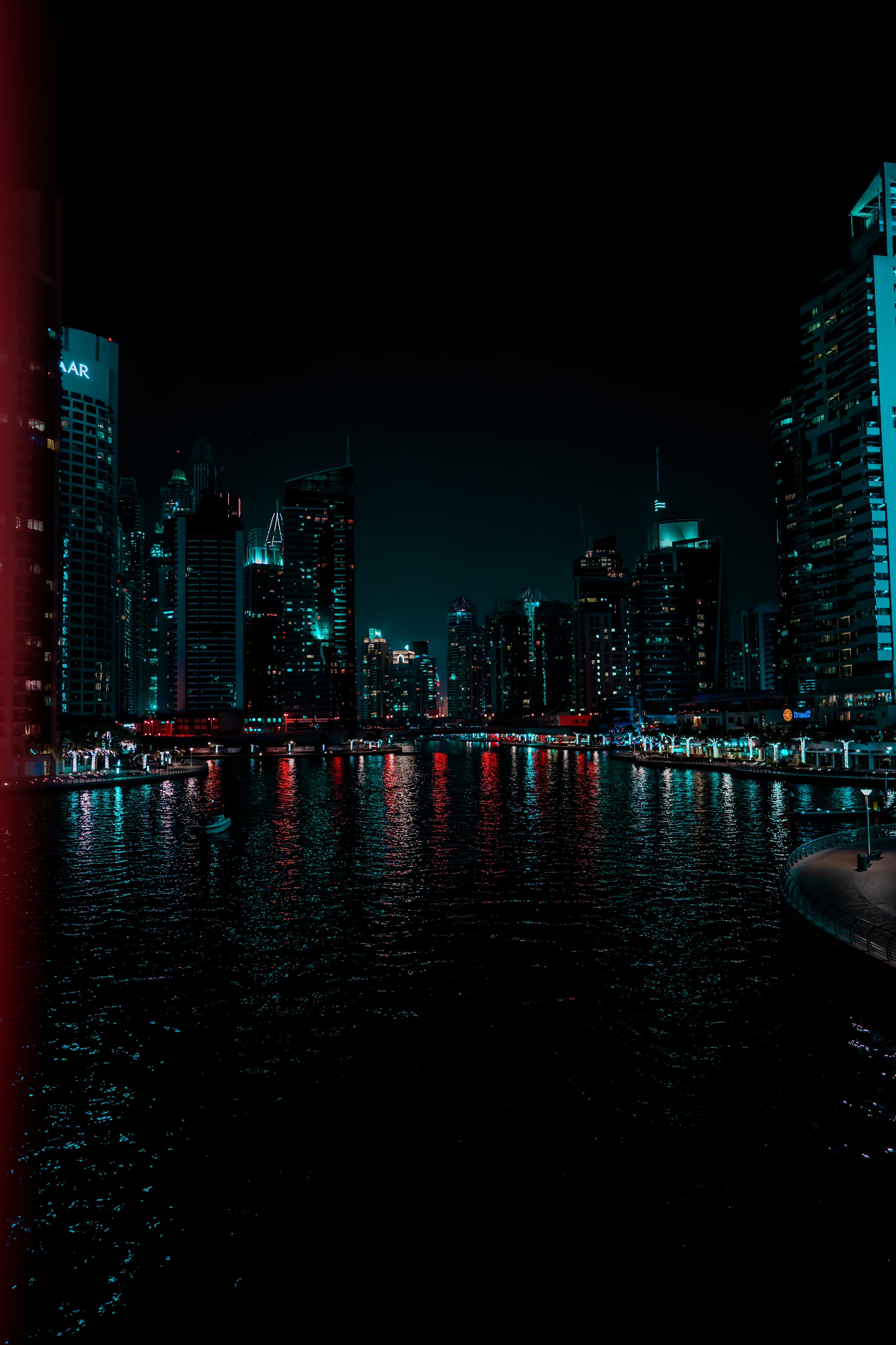 A cityscape with lights and water in the background · Free Stock Photo