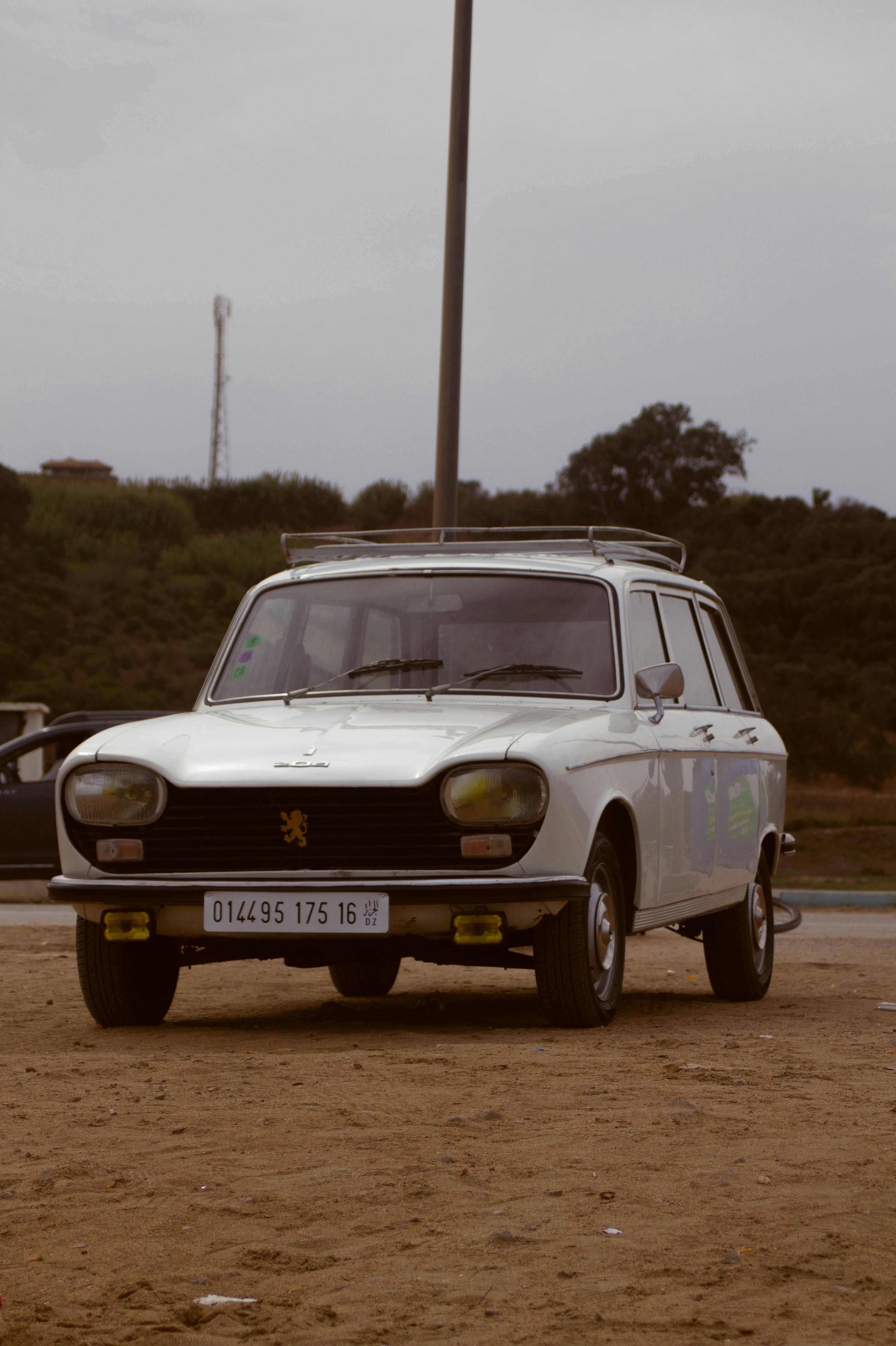 White Peugeot 204 Car Parked on the Brown Sand · Free Stock Photo