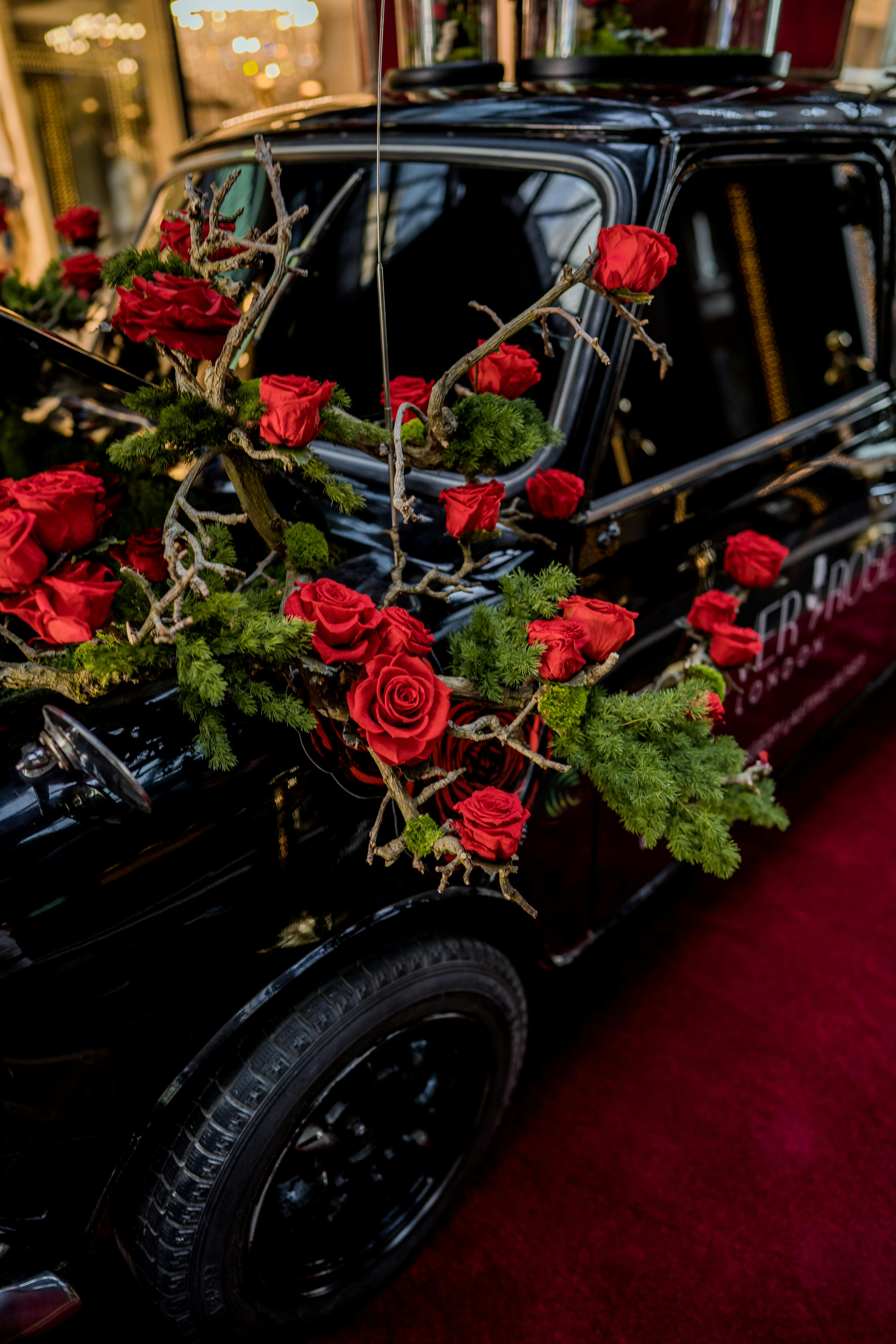 A black car with red roses on the hood · Free Stock Photo