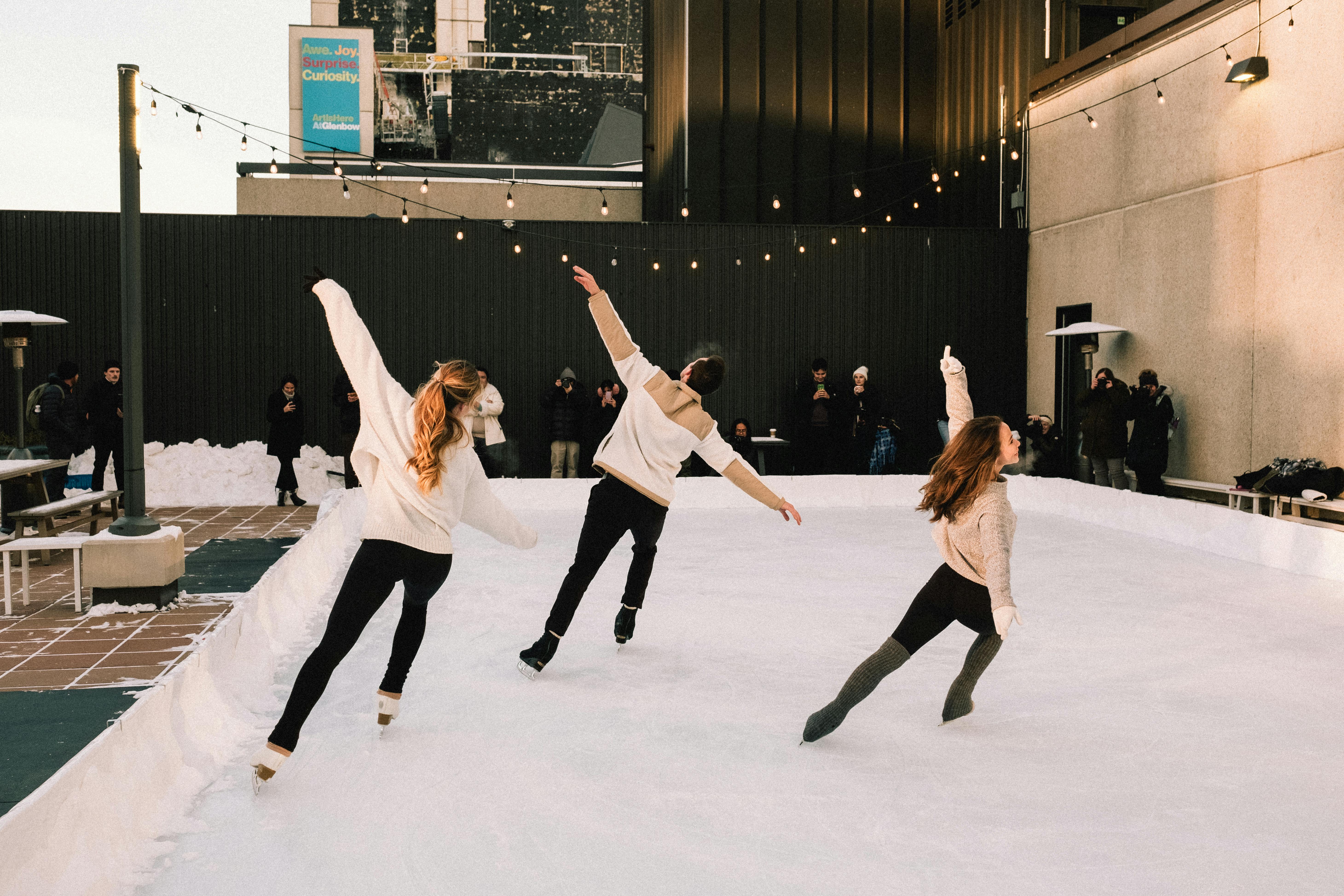 Three People Ice Skating · Free Stock Photo
