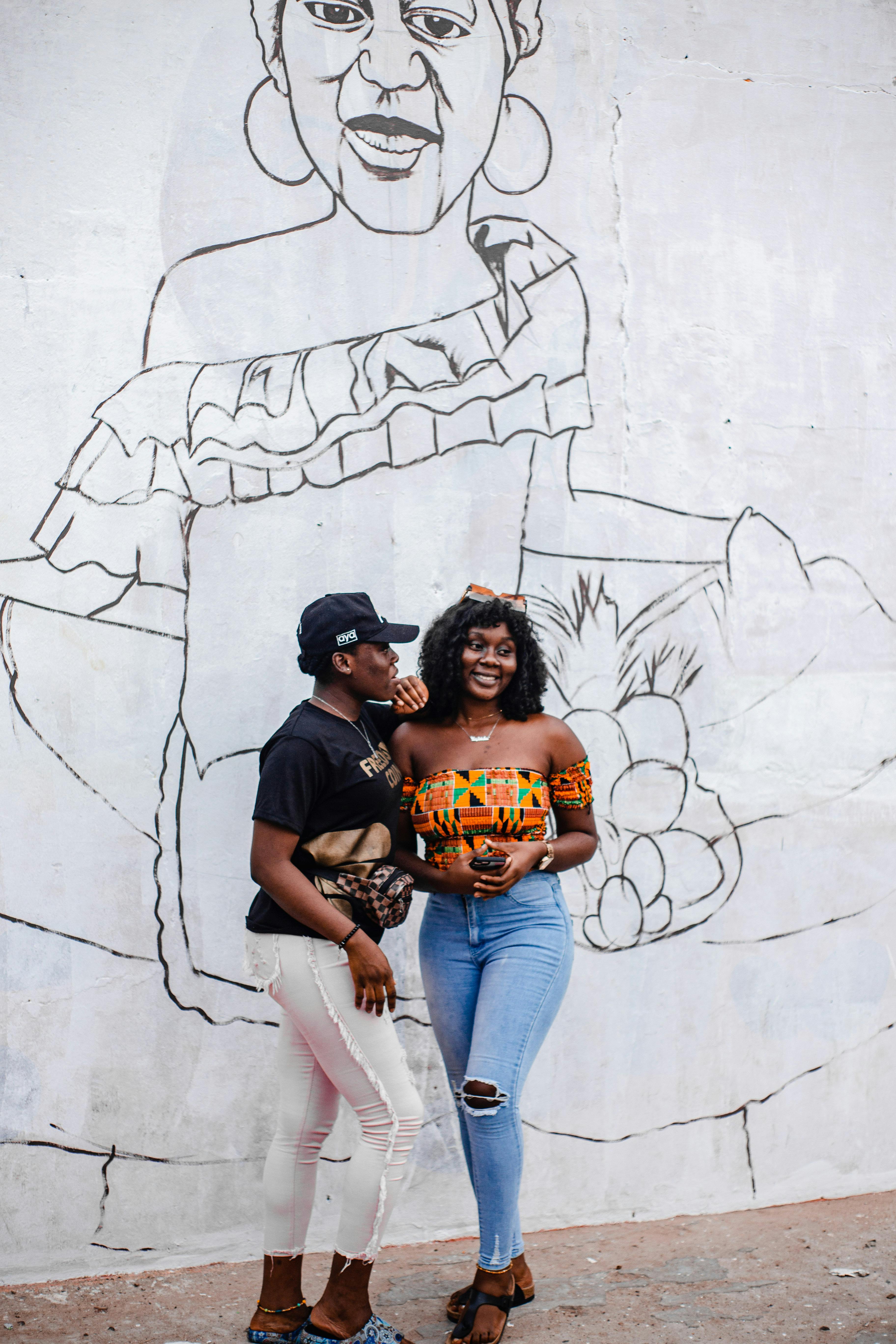 Women Standing Close Together near a Mural · Free Stock Photo