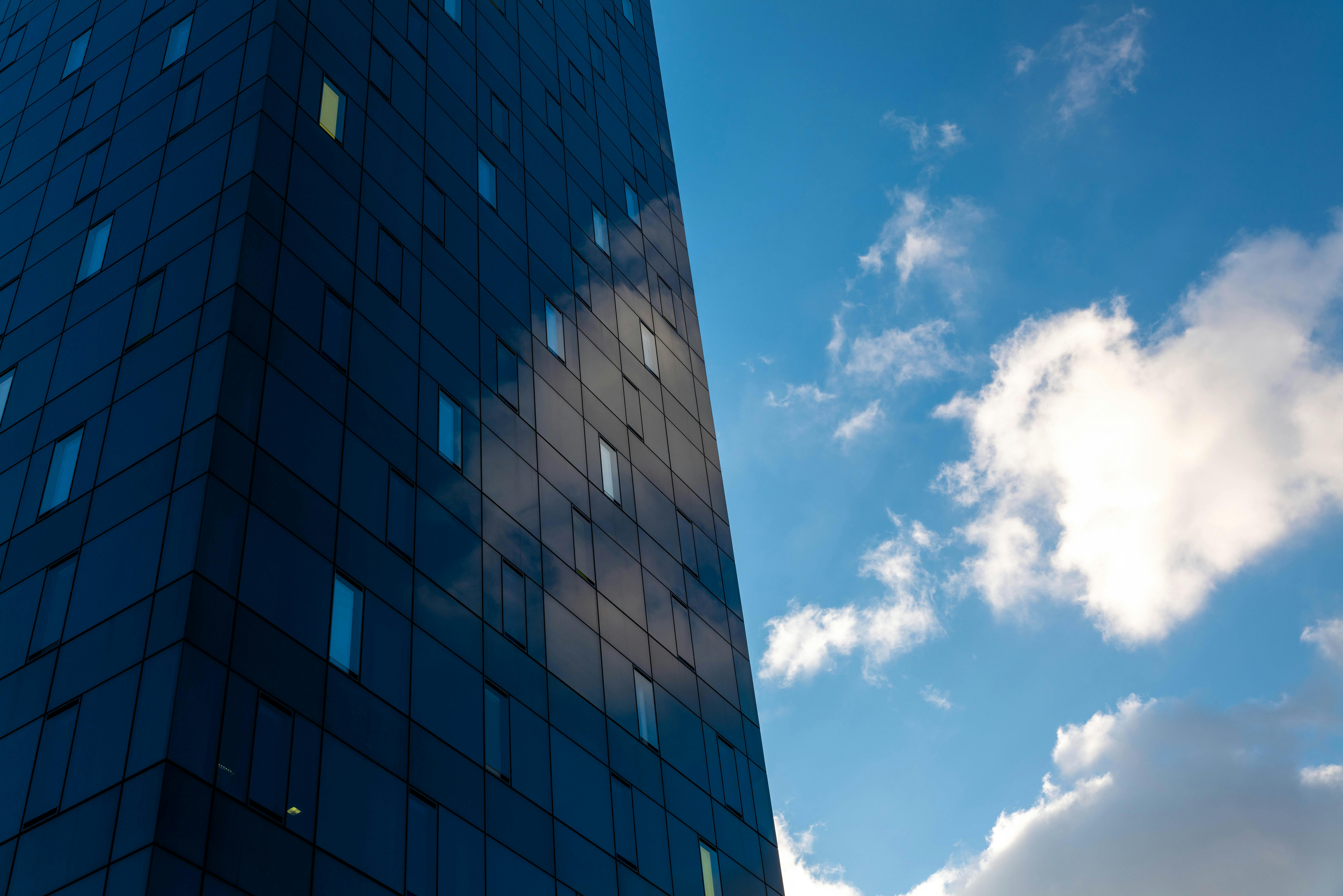 Man Sitting in Front of High Rise Building · Free Stock Photo