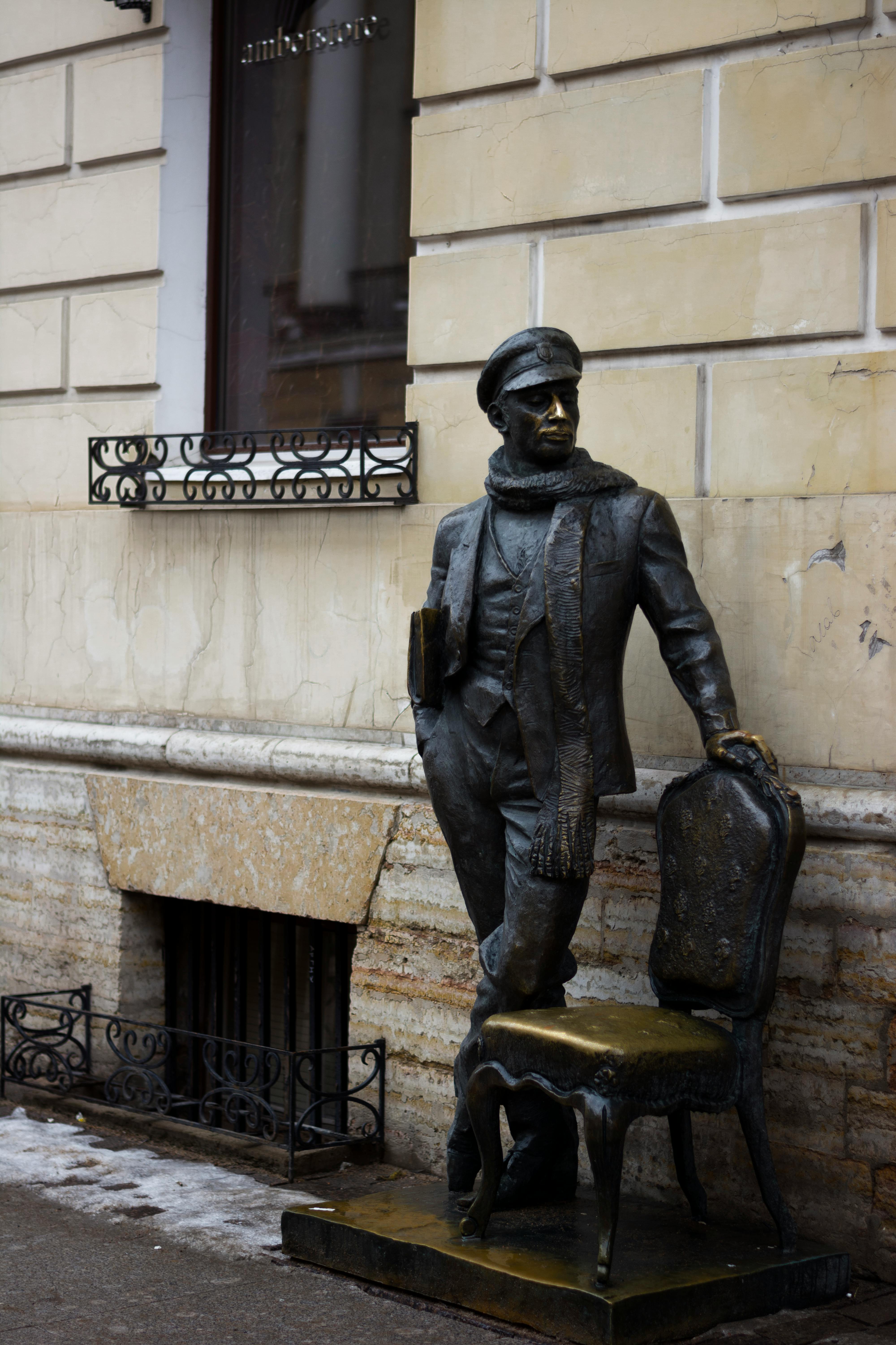 Statue of a Man Standing and Leaning on the Chair · Free Stock Photo