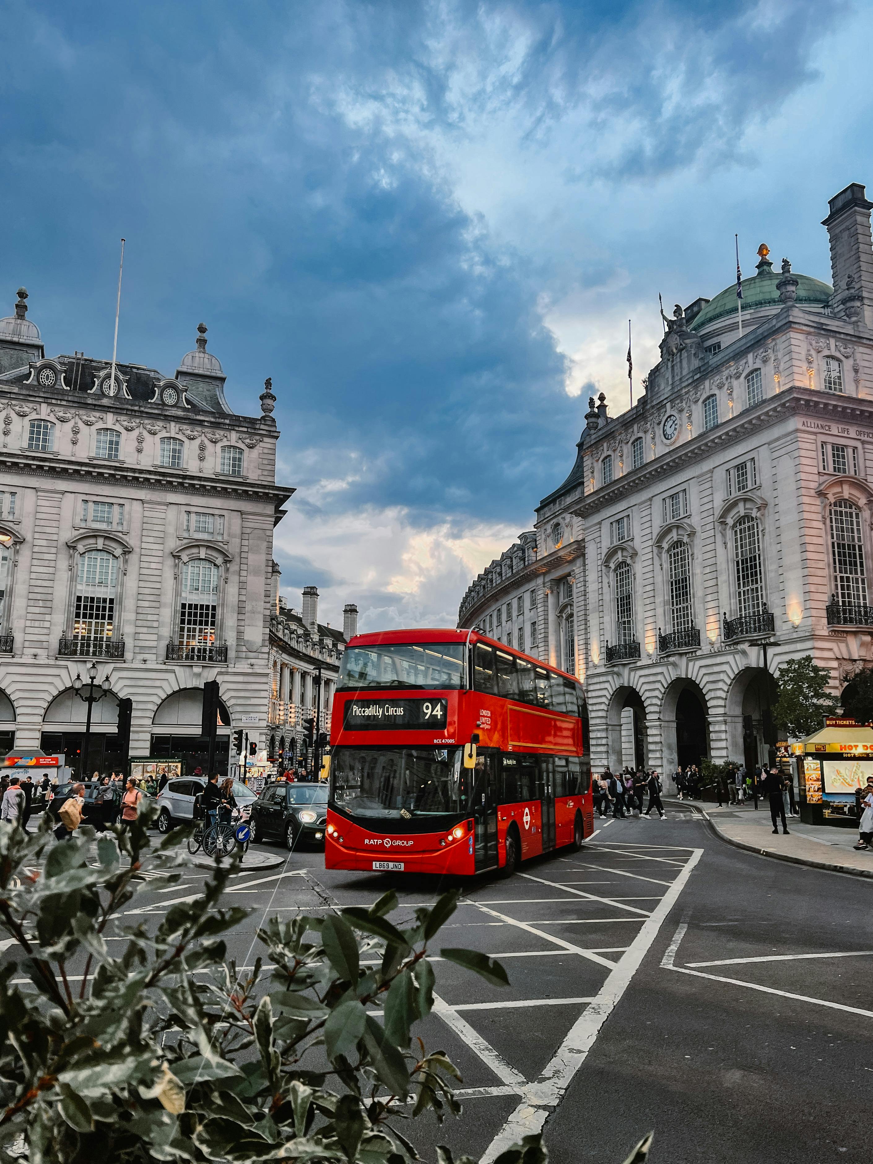 Red Bus on City Street near Concrete Buildings · Free Stock Photo