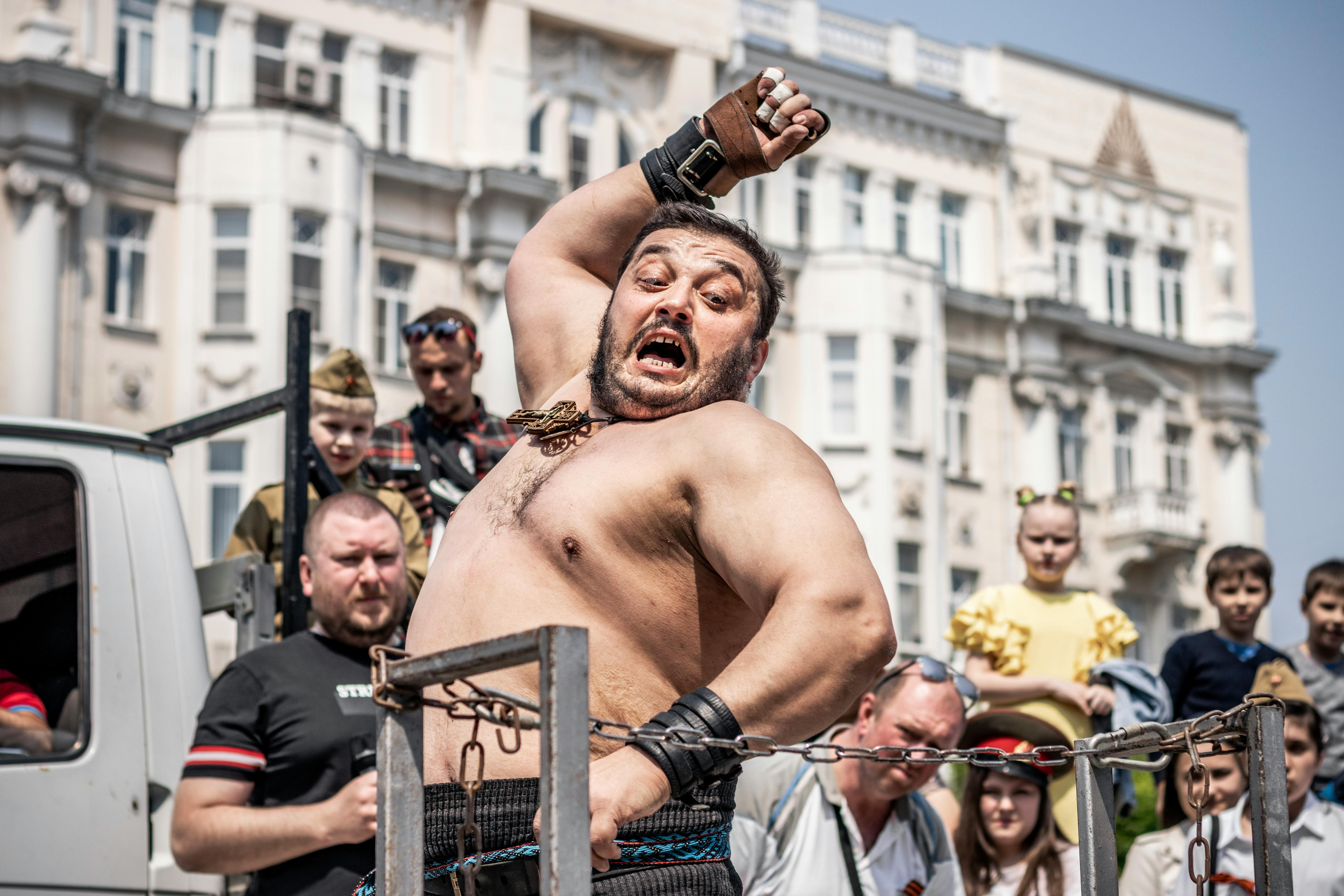 Photo of a Man Hitting a Chain at a Festival · Free Stock Photo