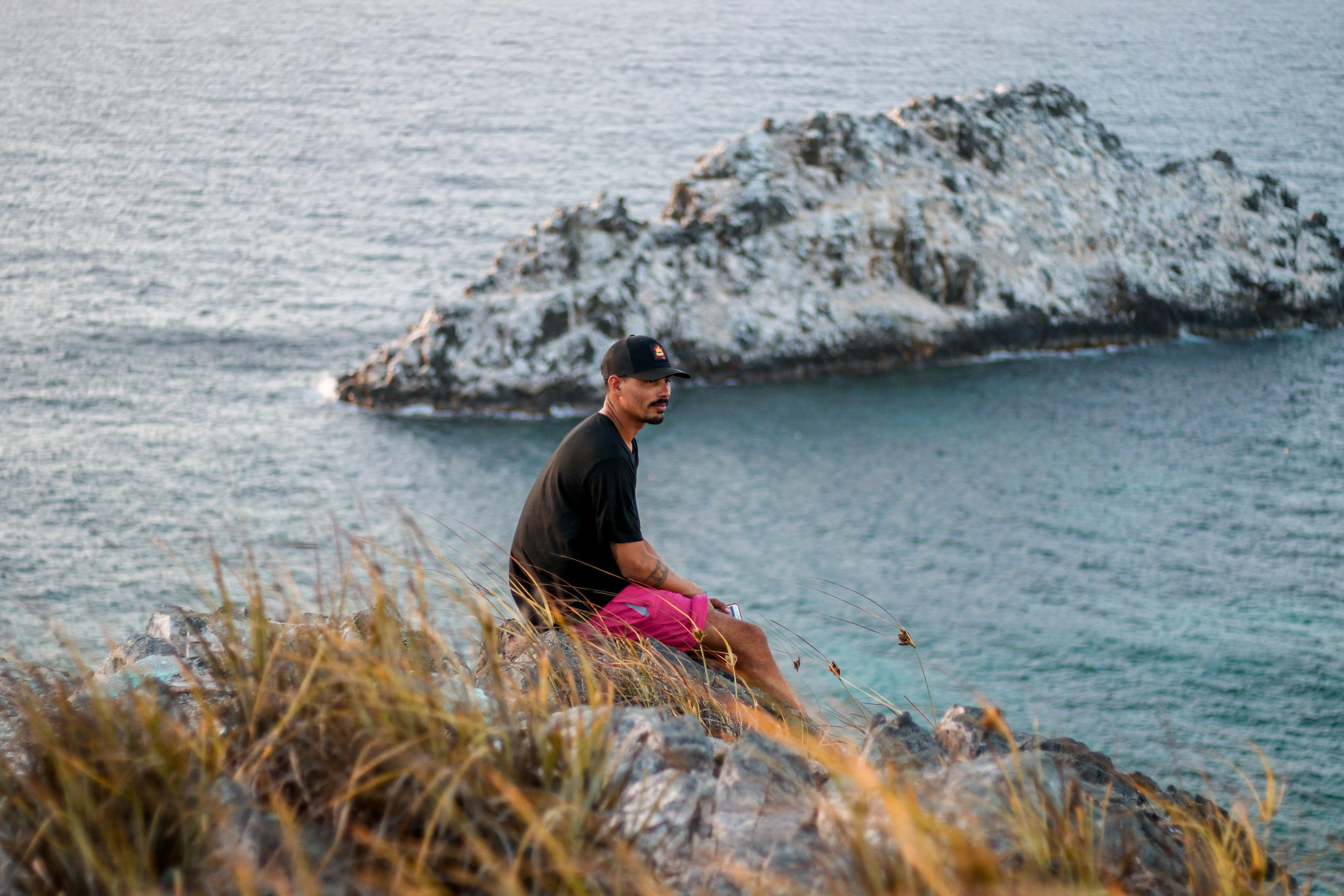 Photo of a Man Sitting on the Cliff · Free Stock Photo