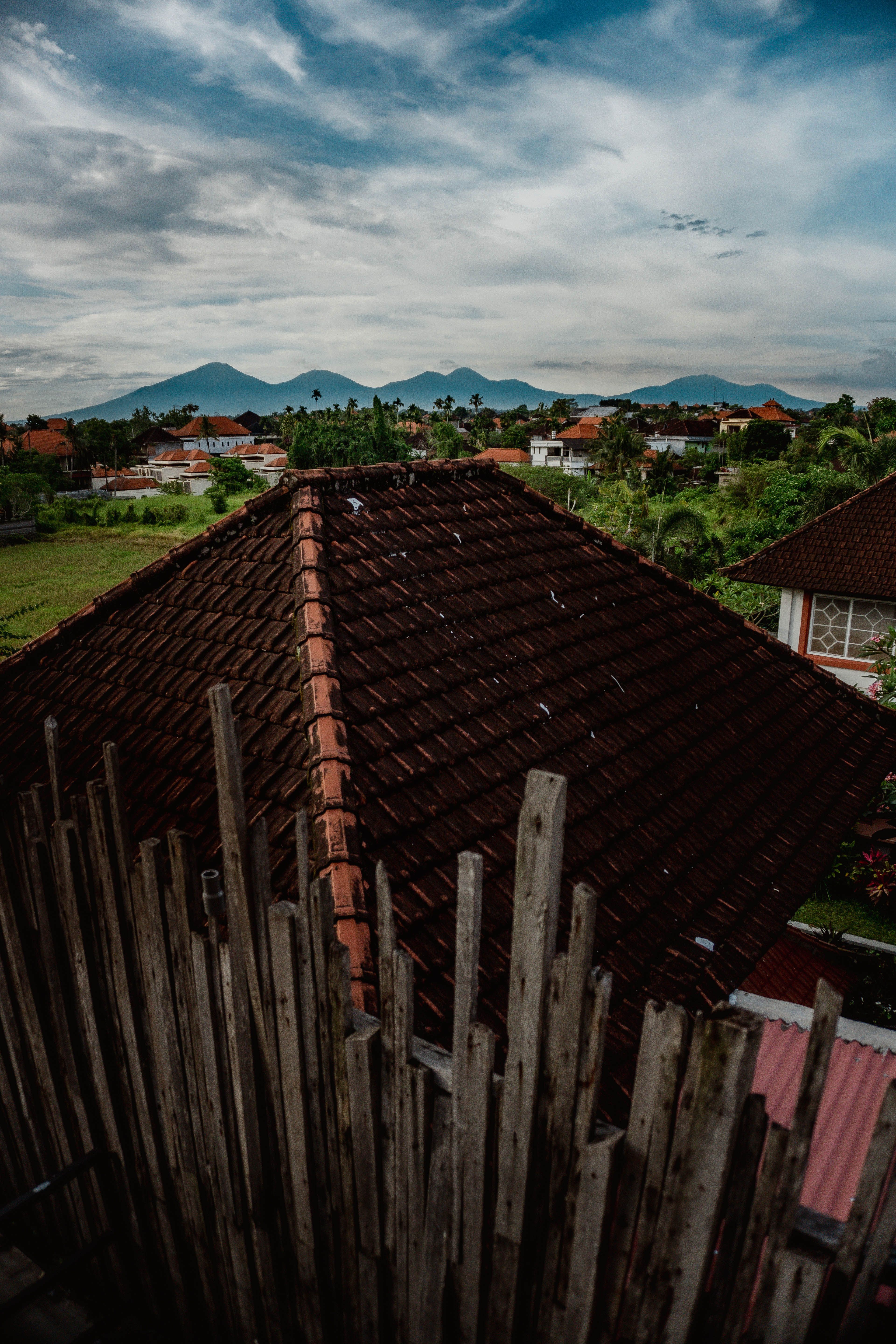 A Wooden Fence near a House Roof · Free Stock Photo