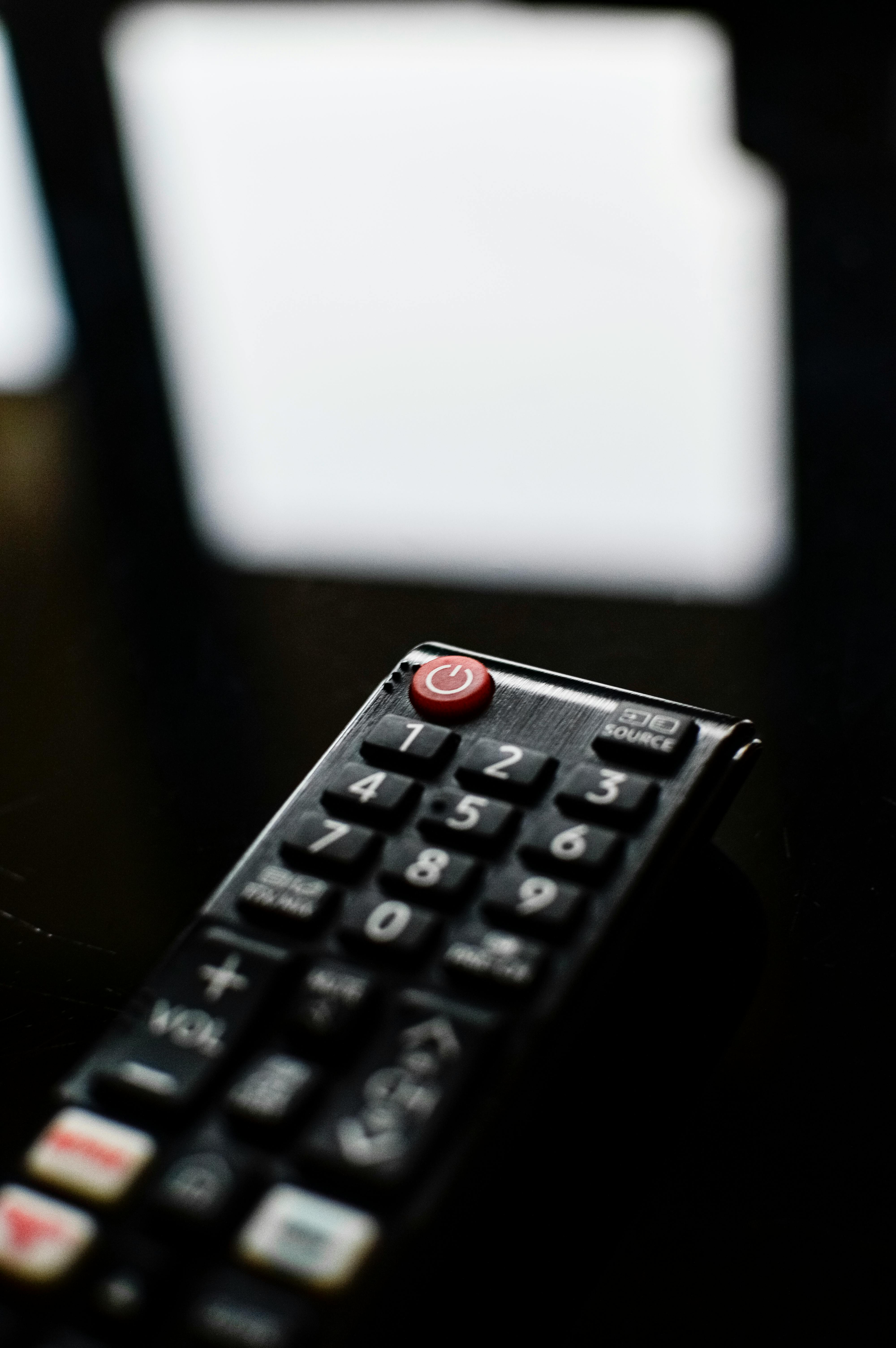 Person Holding a Black Remote Control · Free Stock Photo