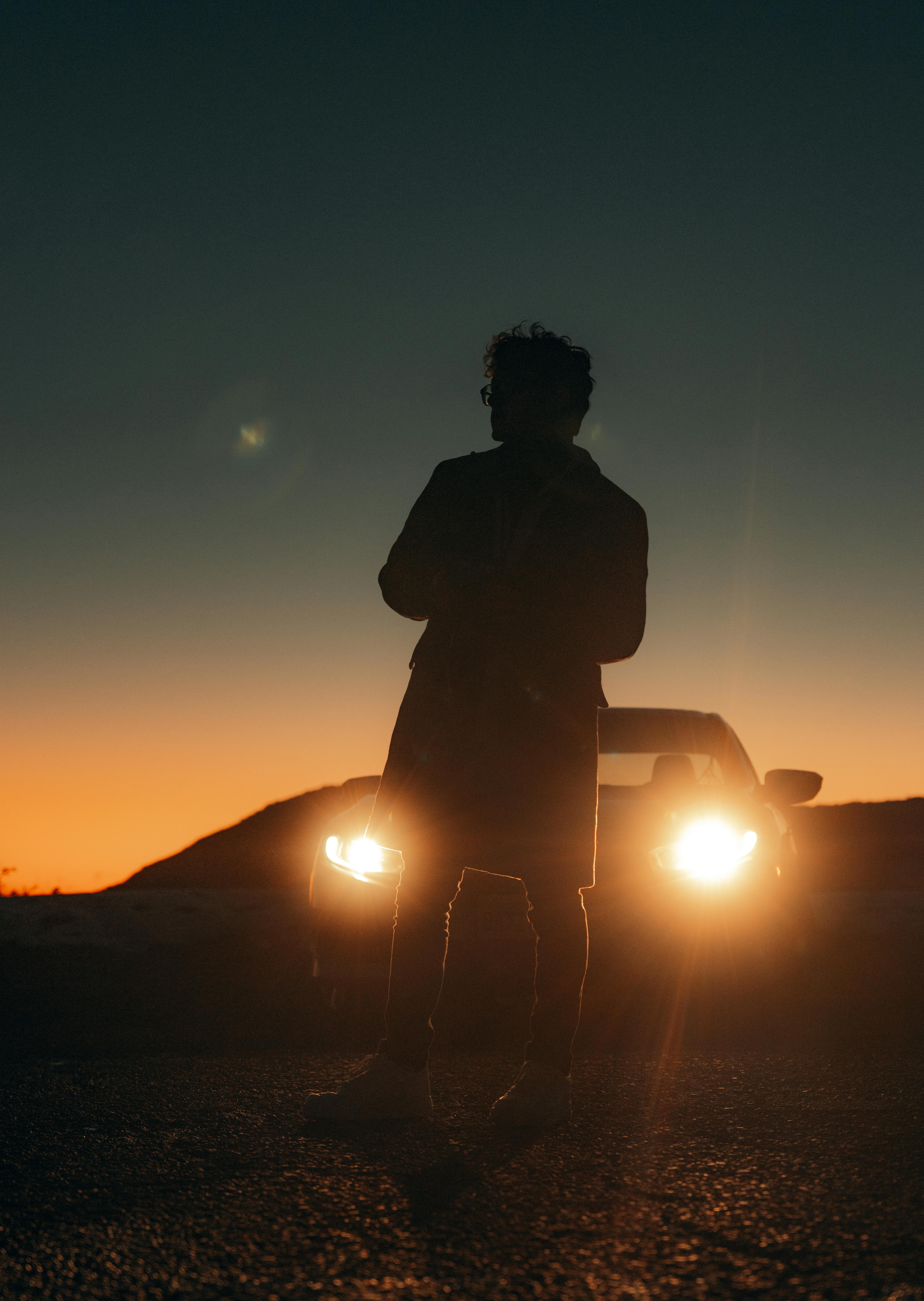 Photo of Person Standing in front of a Car · Free Stock Photo