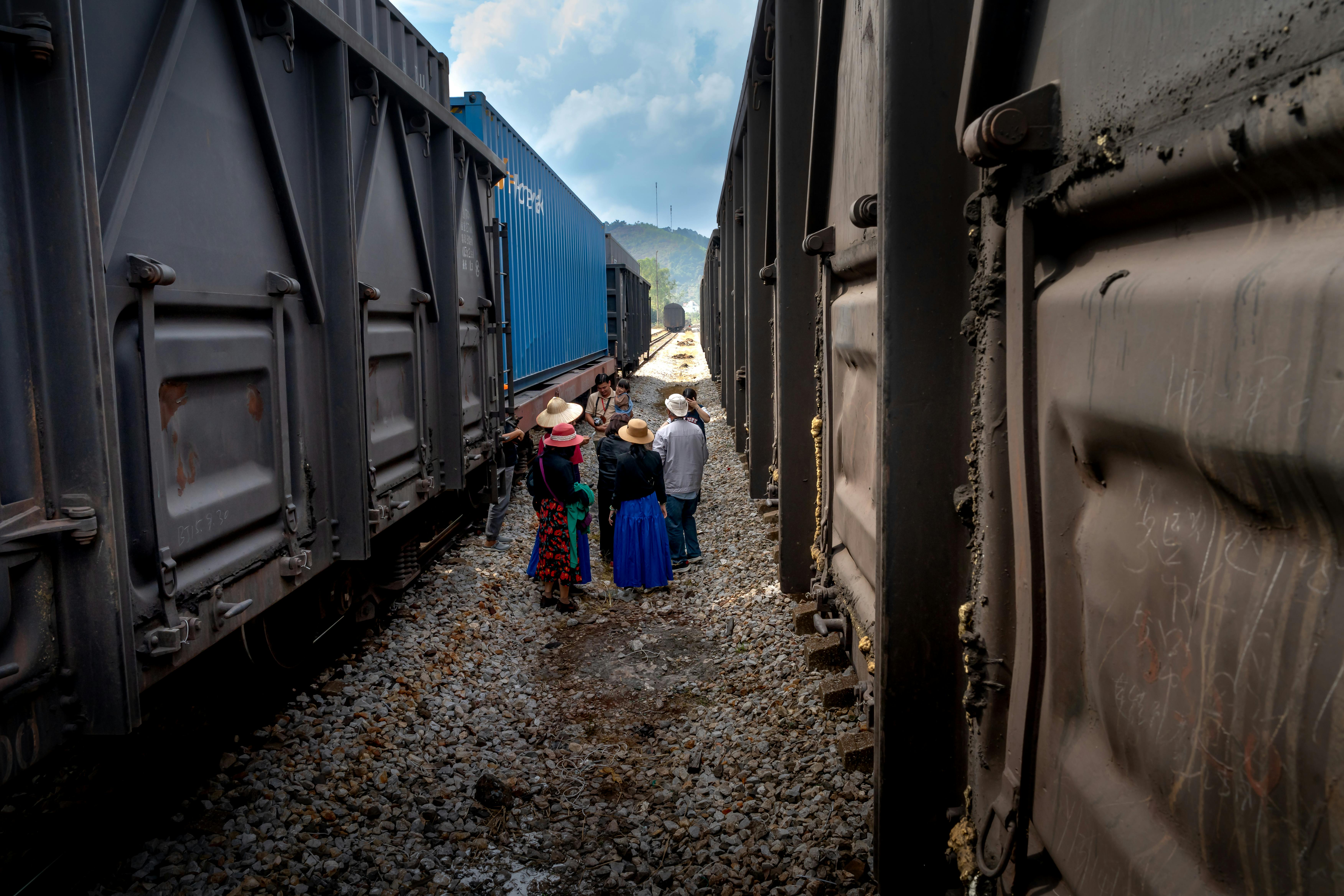 A Group of People Standing Between Cargo Train · Free Stock Photo