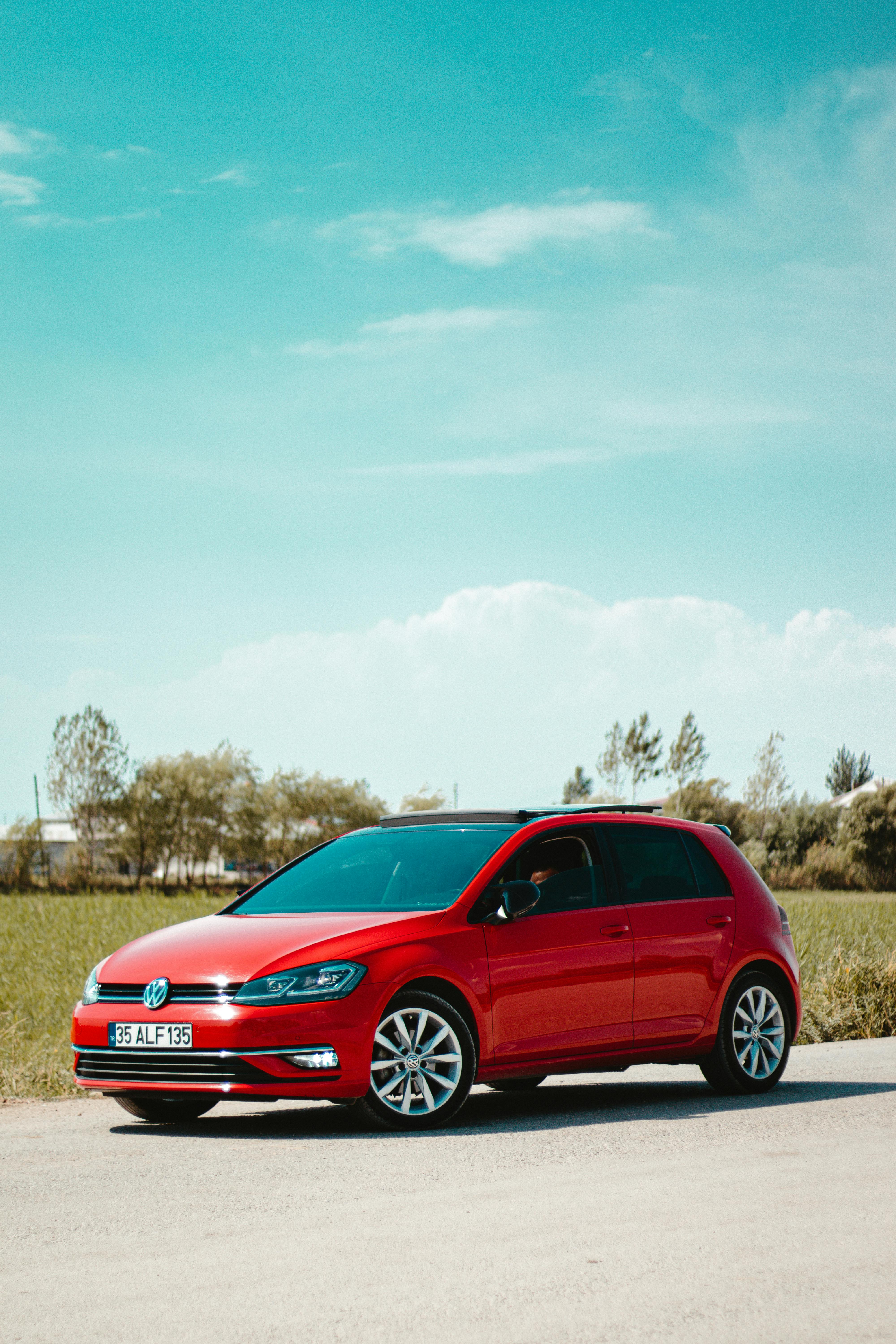 A Red Car Parked on the Road Near the Field · Free Stock Photo