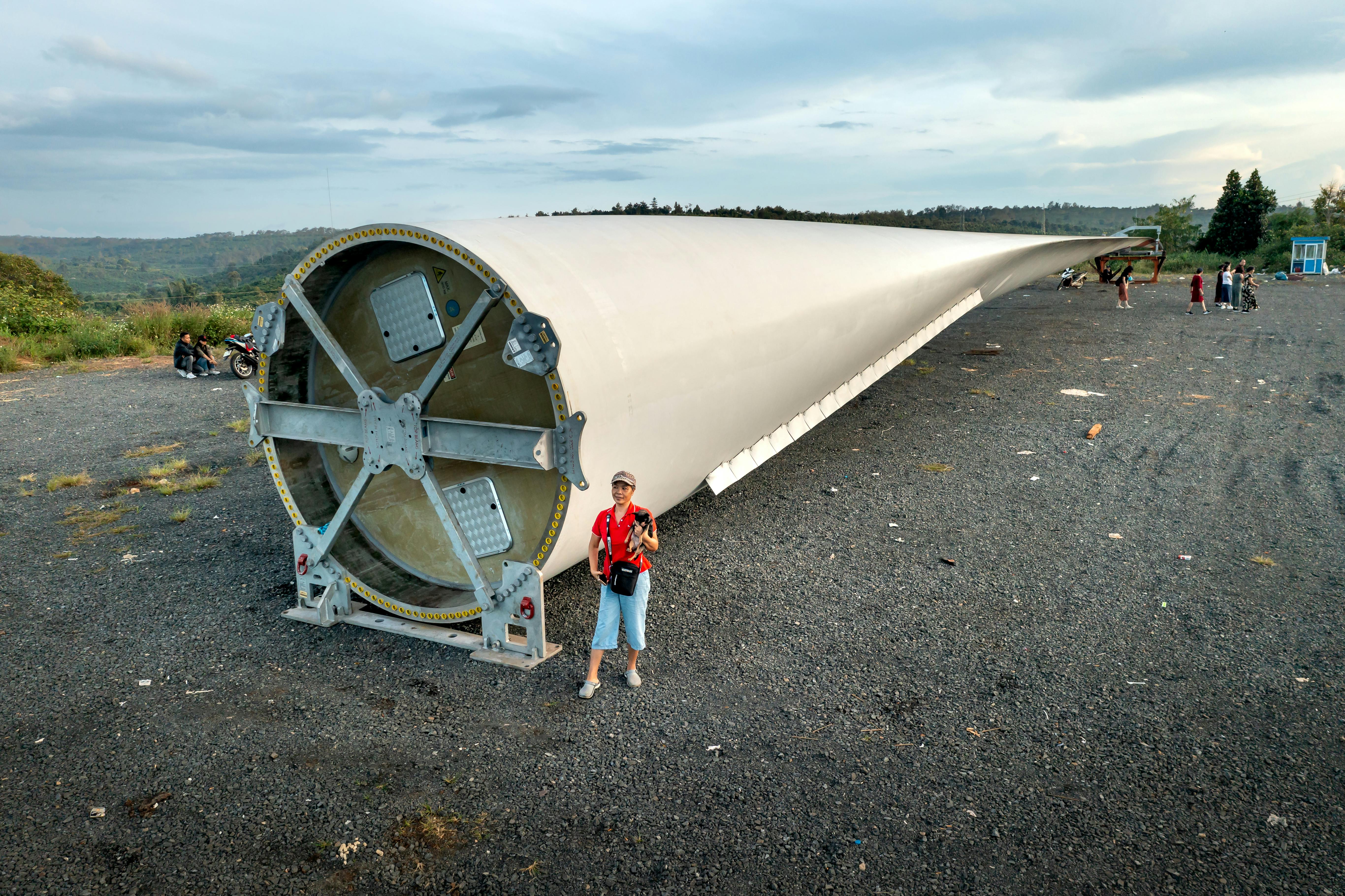 Woman Posing next to a Large Wind Turbine Wing on the Ground · Free ...
