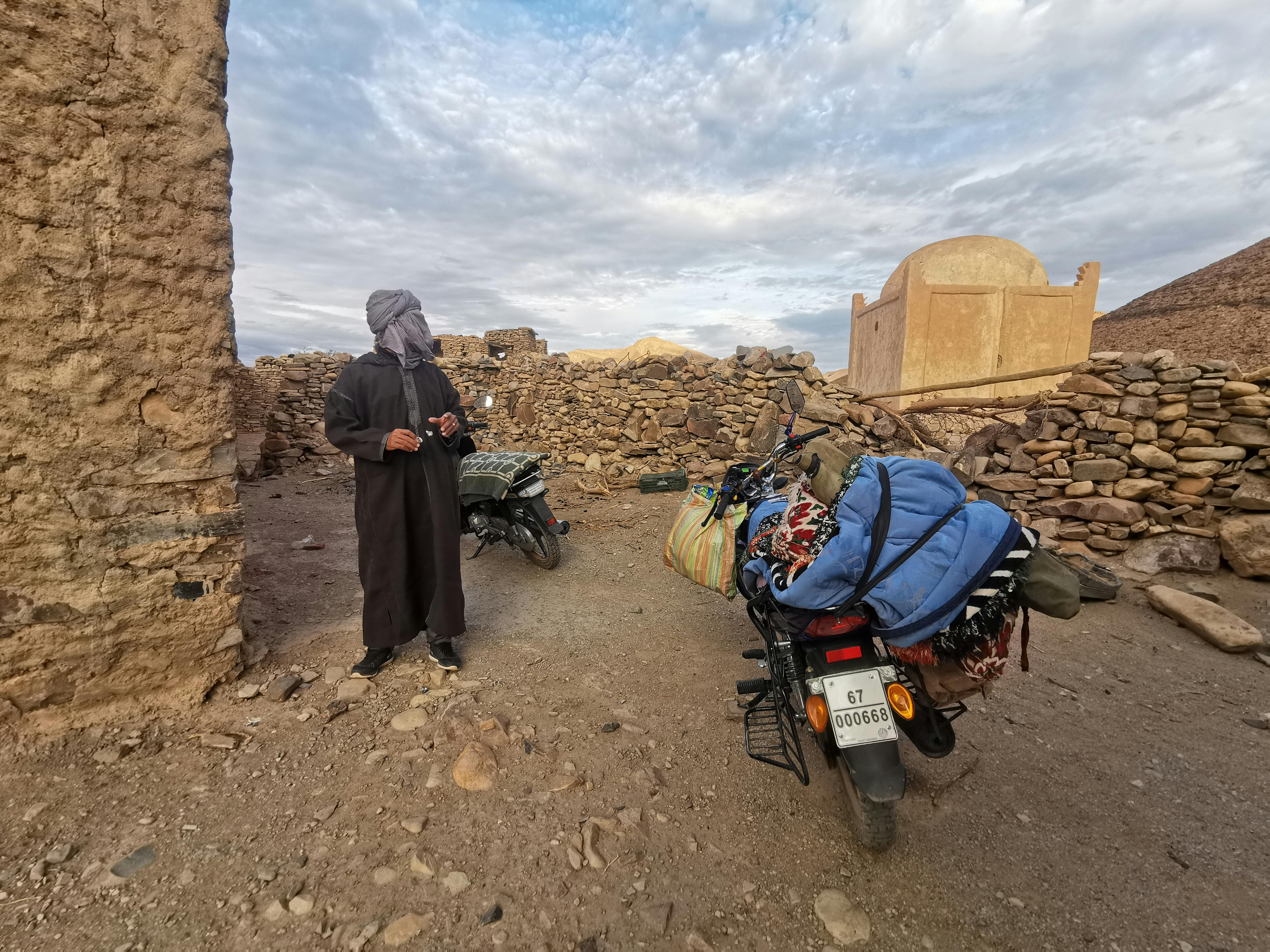 Bedouin with Motorbike near Ancient Building · Free Stock Photo
