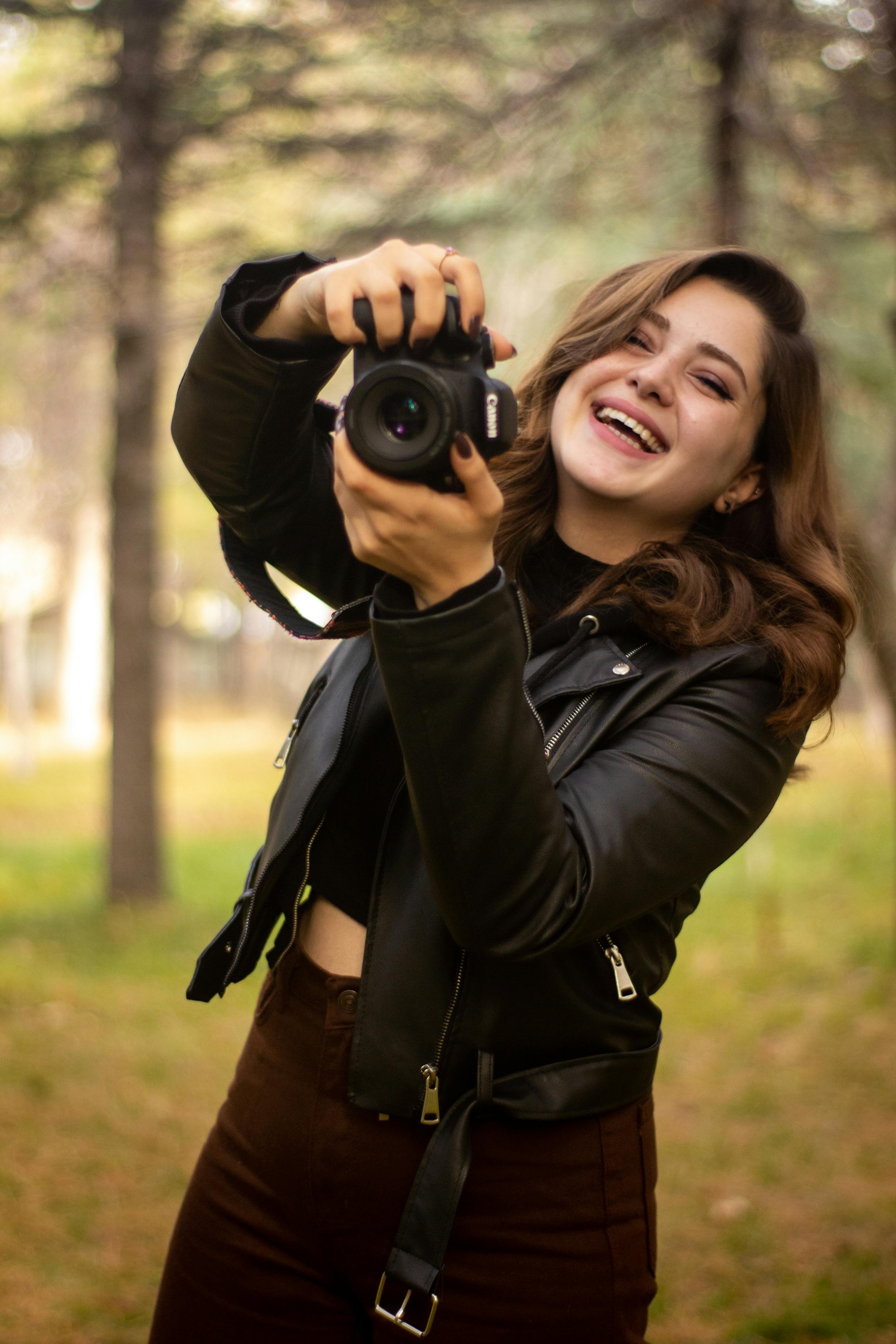 Woman Holding and Using a Camera · Free Stock Photo