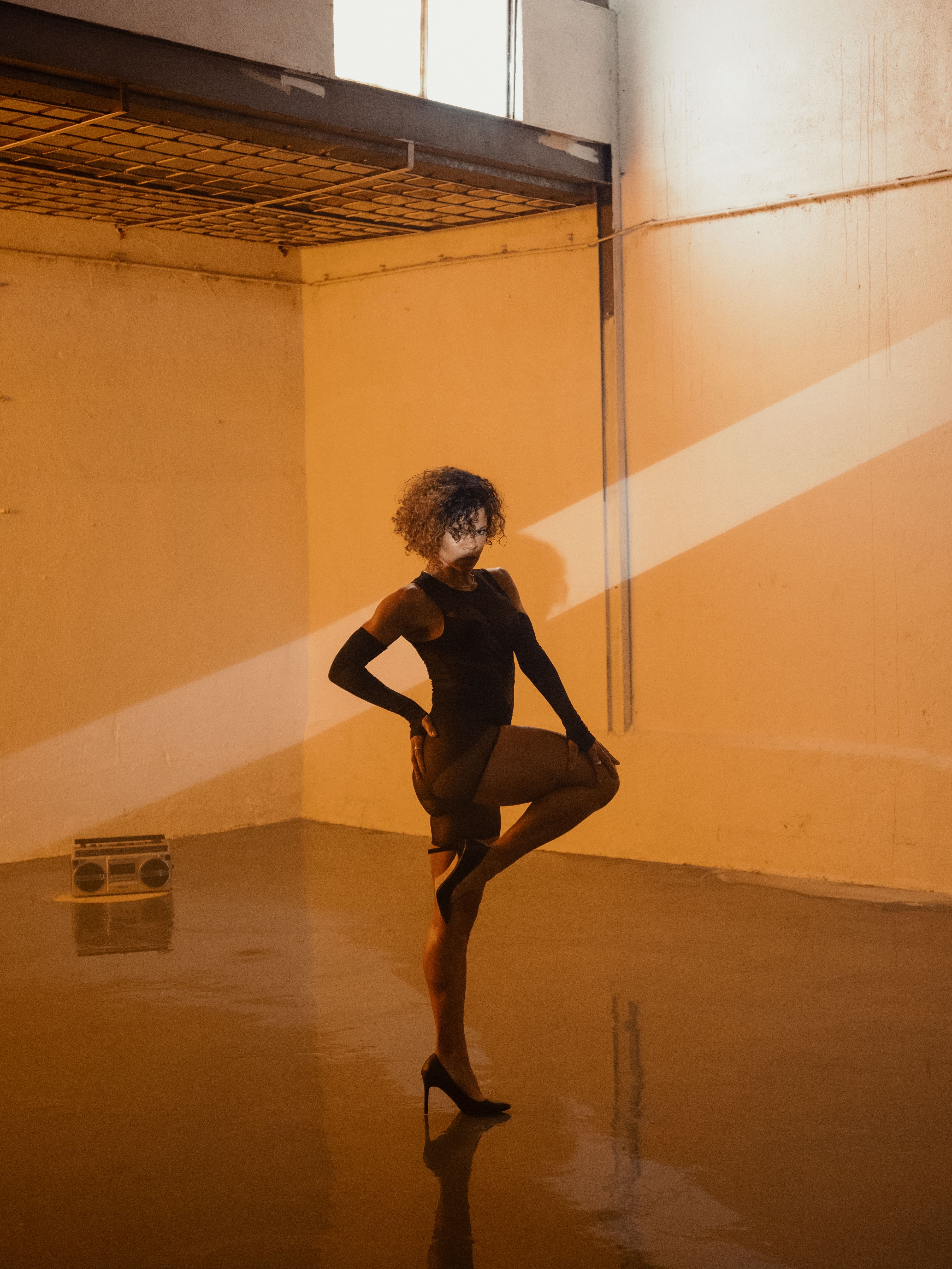 Female Model Posing on One Leg in Front of a Wall · Free Stock Photo