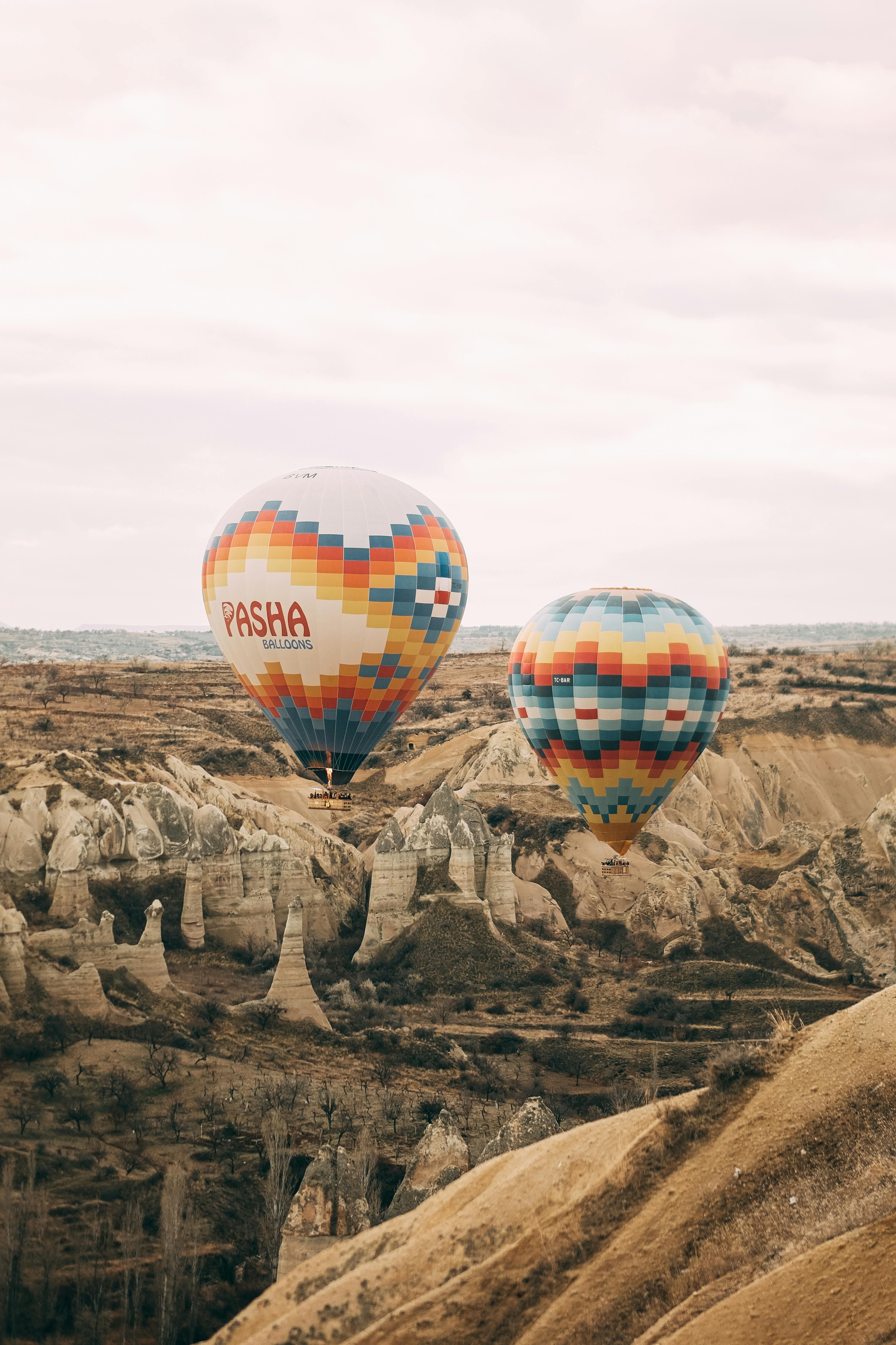 Balloons Flying Over Rocky Terrain · Free Stock Photo