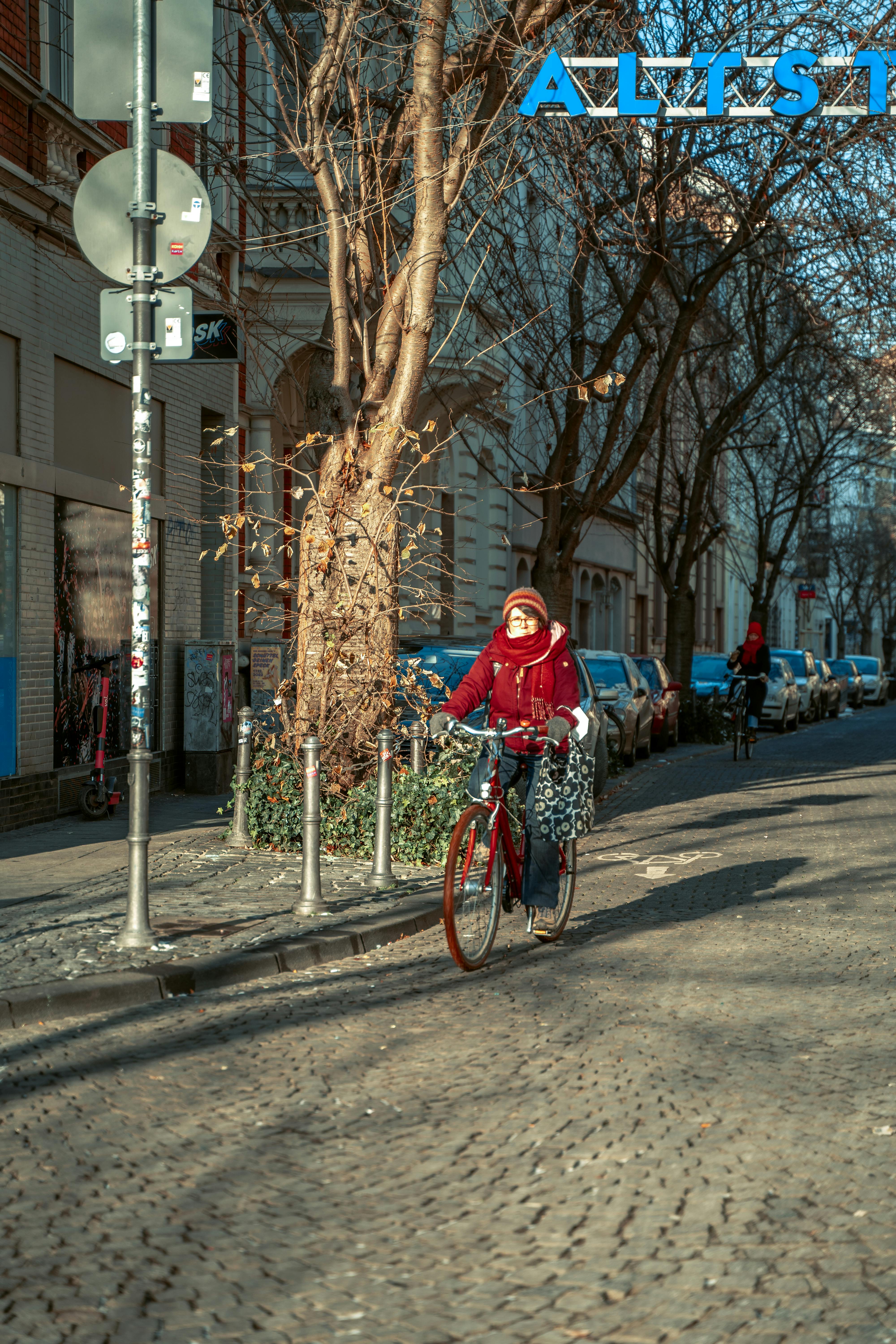 Woman on Bike on Cobblestone Street · Free Stock Photo