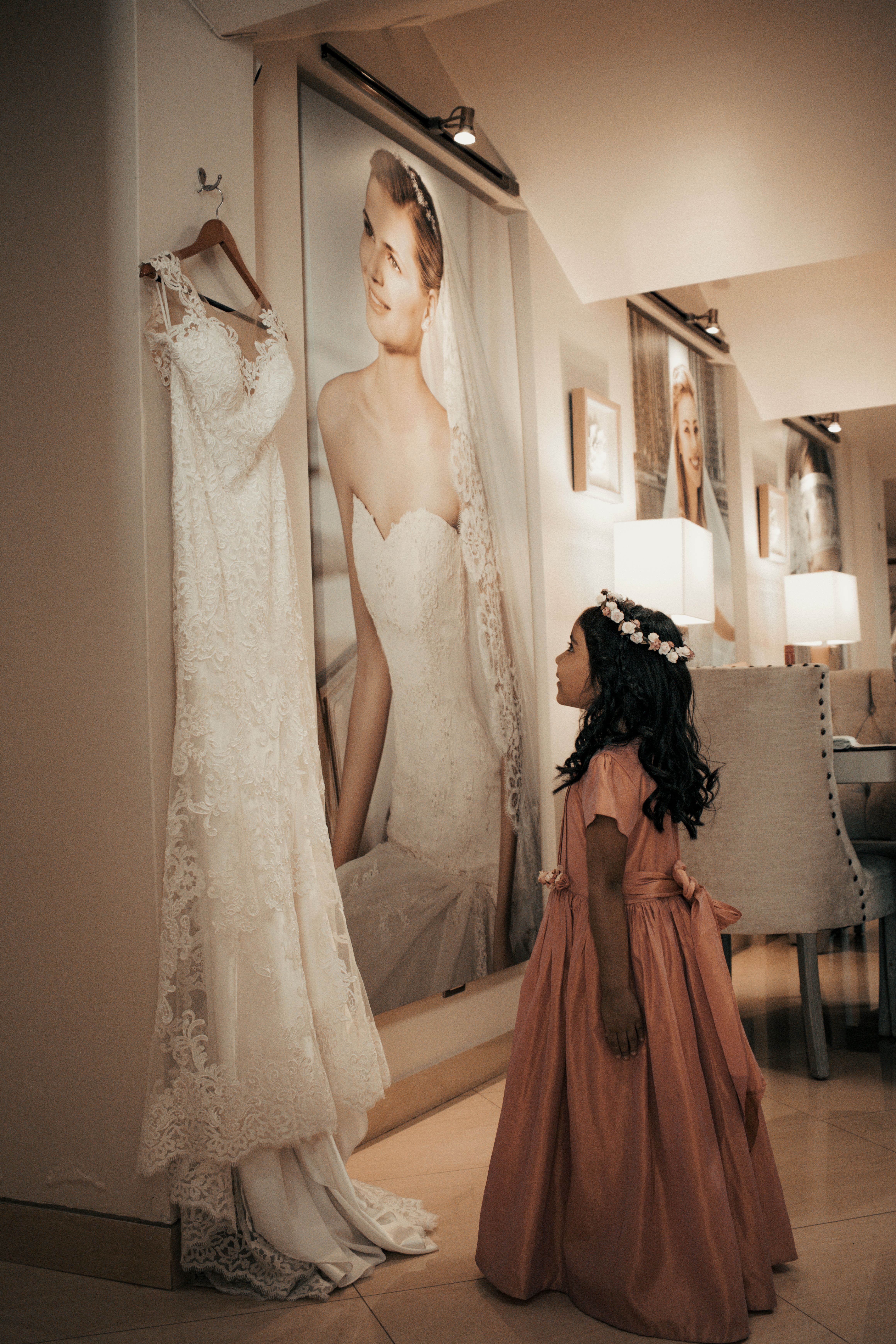 A Girl Staring at the Hanging Wedding Dress · Free Stock Photo