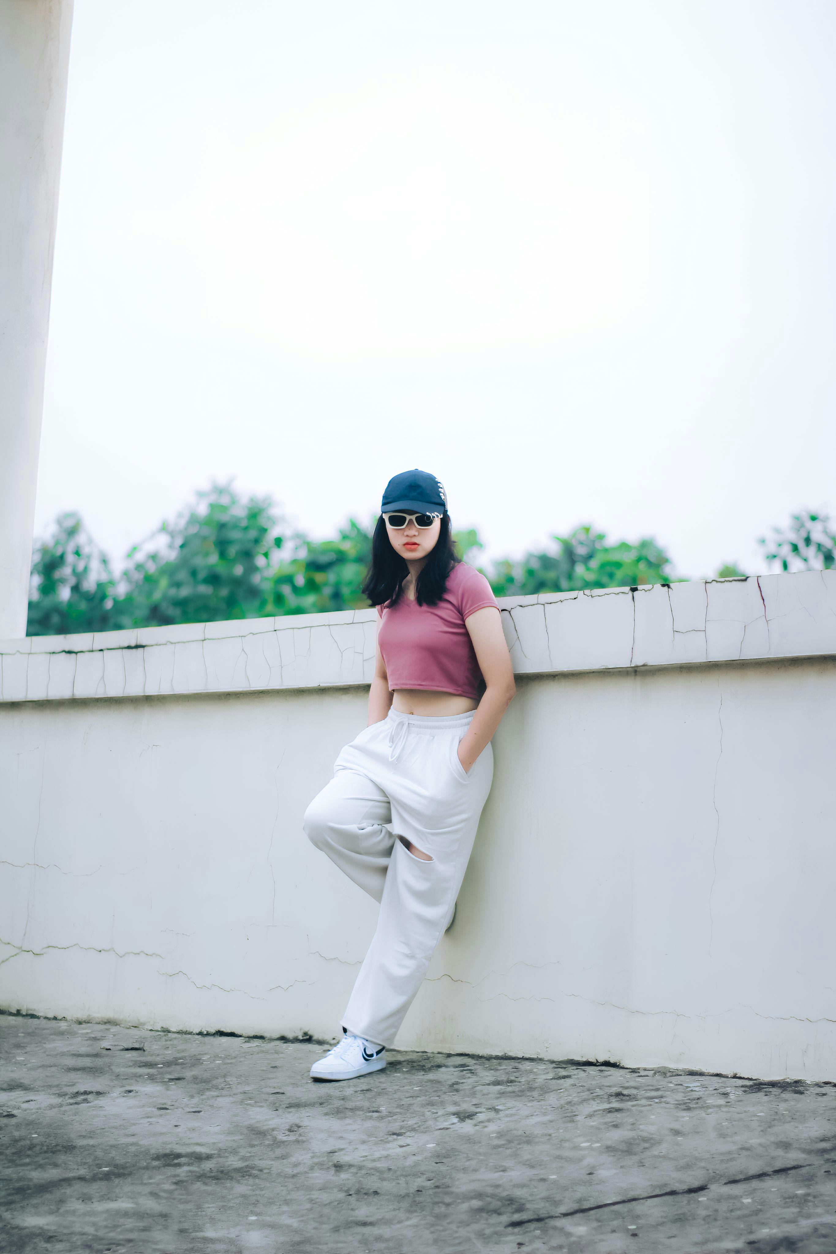 Seorang Wanita Dengan Crop Top Merah Muda Bersandar Di Railing Beton ...