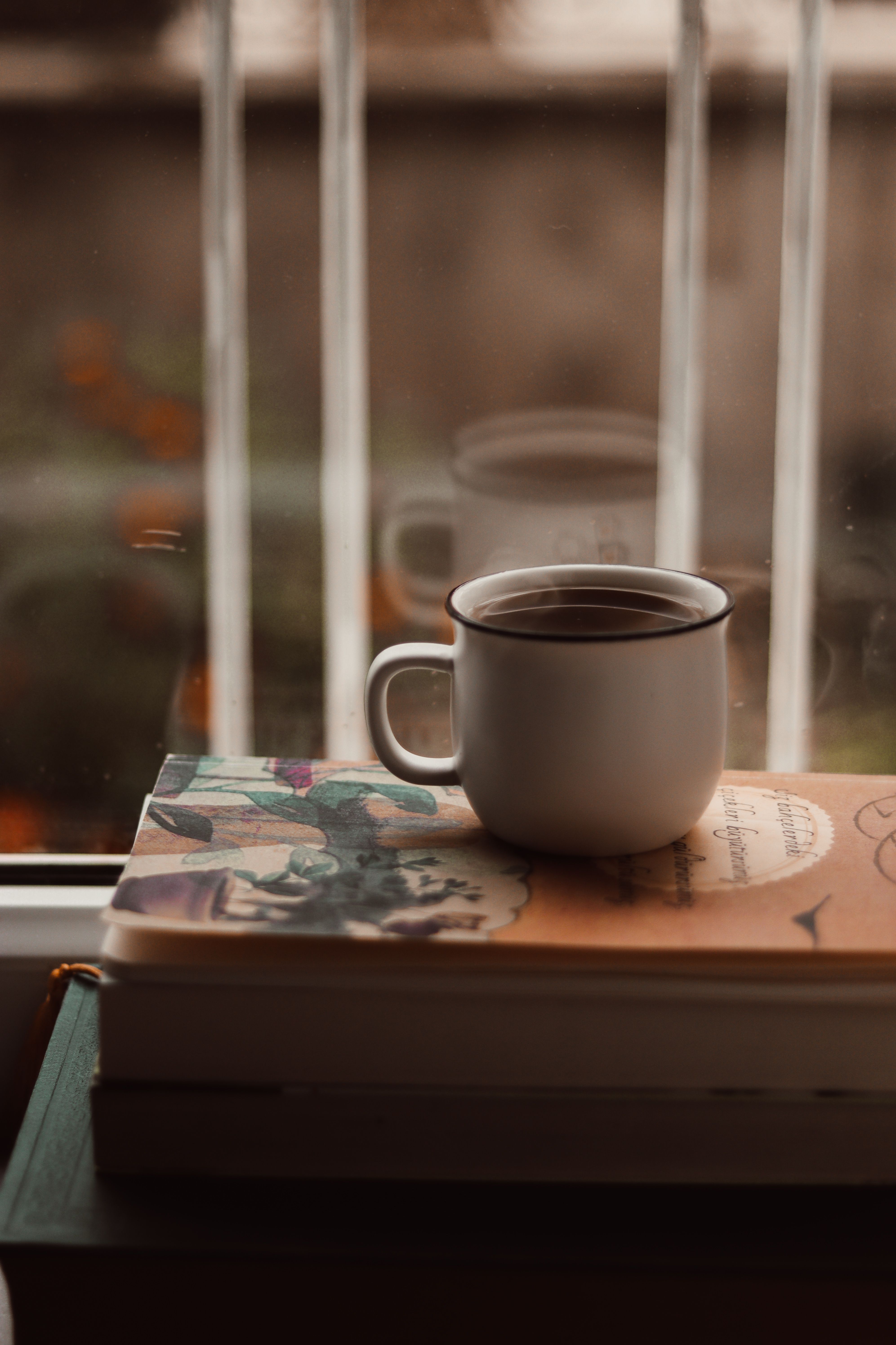 Cup of Coffee on Stack of Books by Window · Free Stock Photo