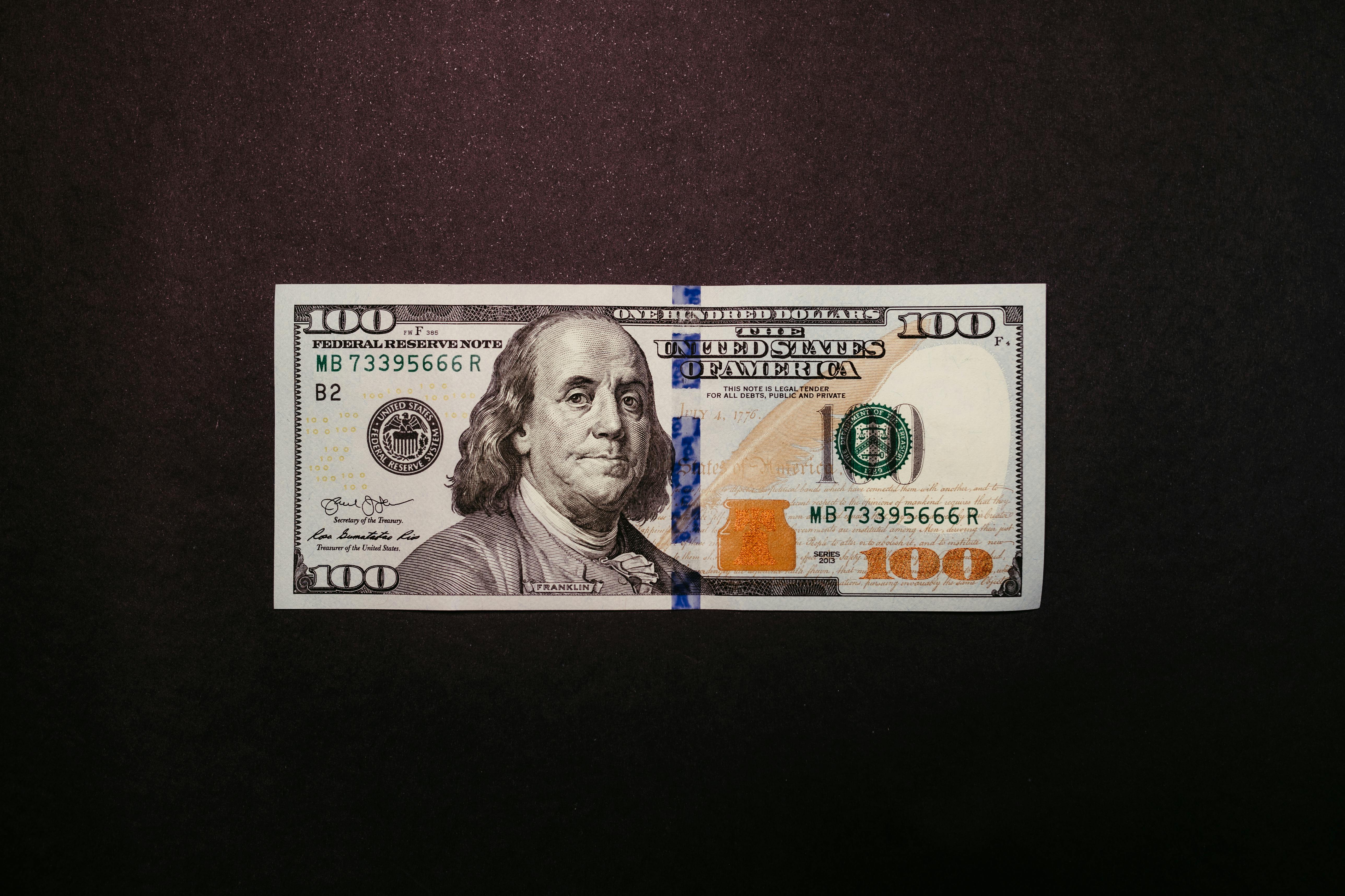 One Hundred Dollar Bill on Black Background · Free Stock Photo