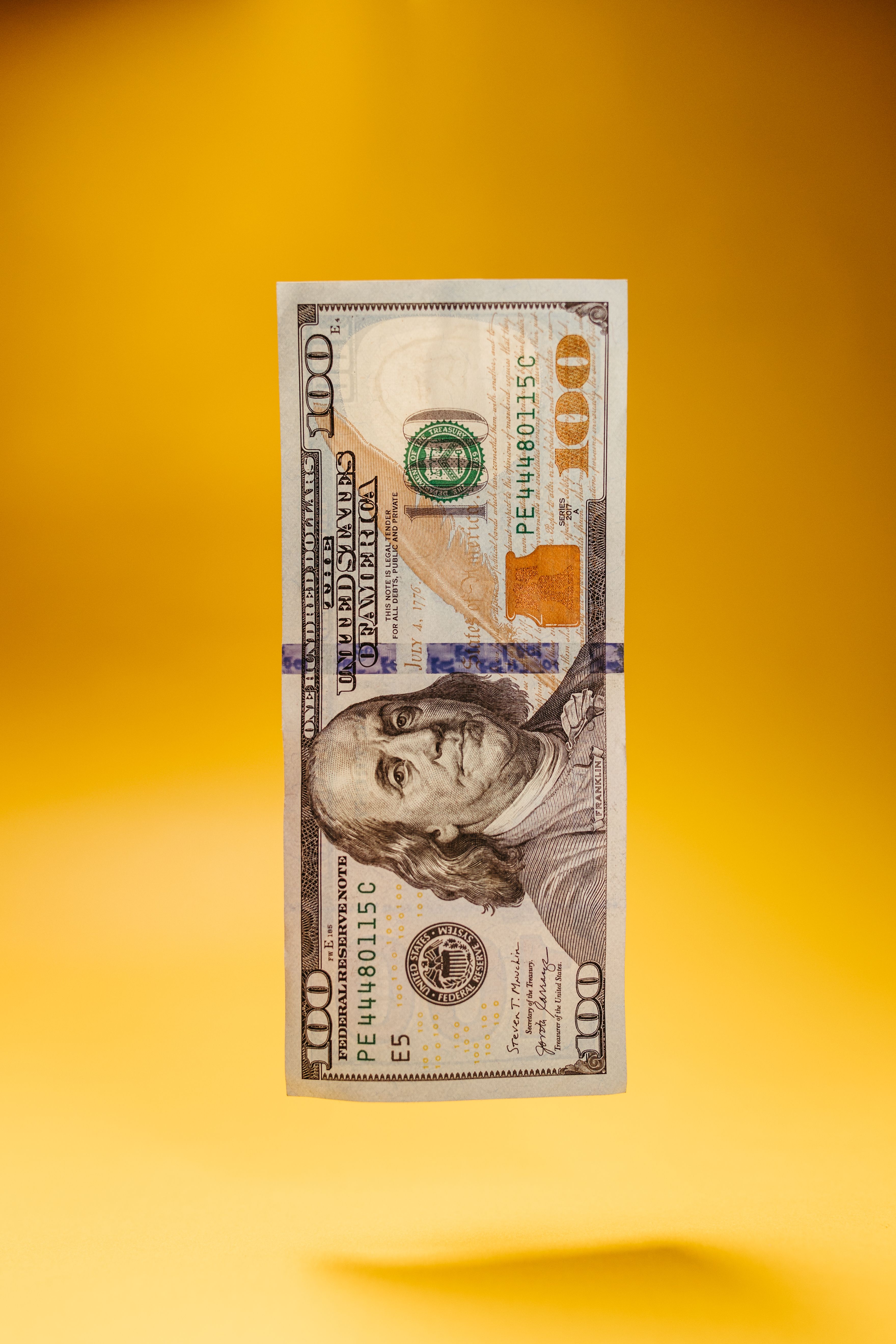 Close-Up Shot of a Paper Money on Yellow Background · Free Stock Photo