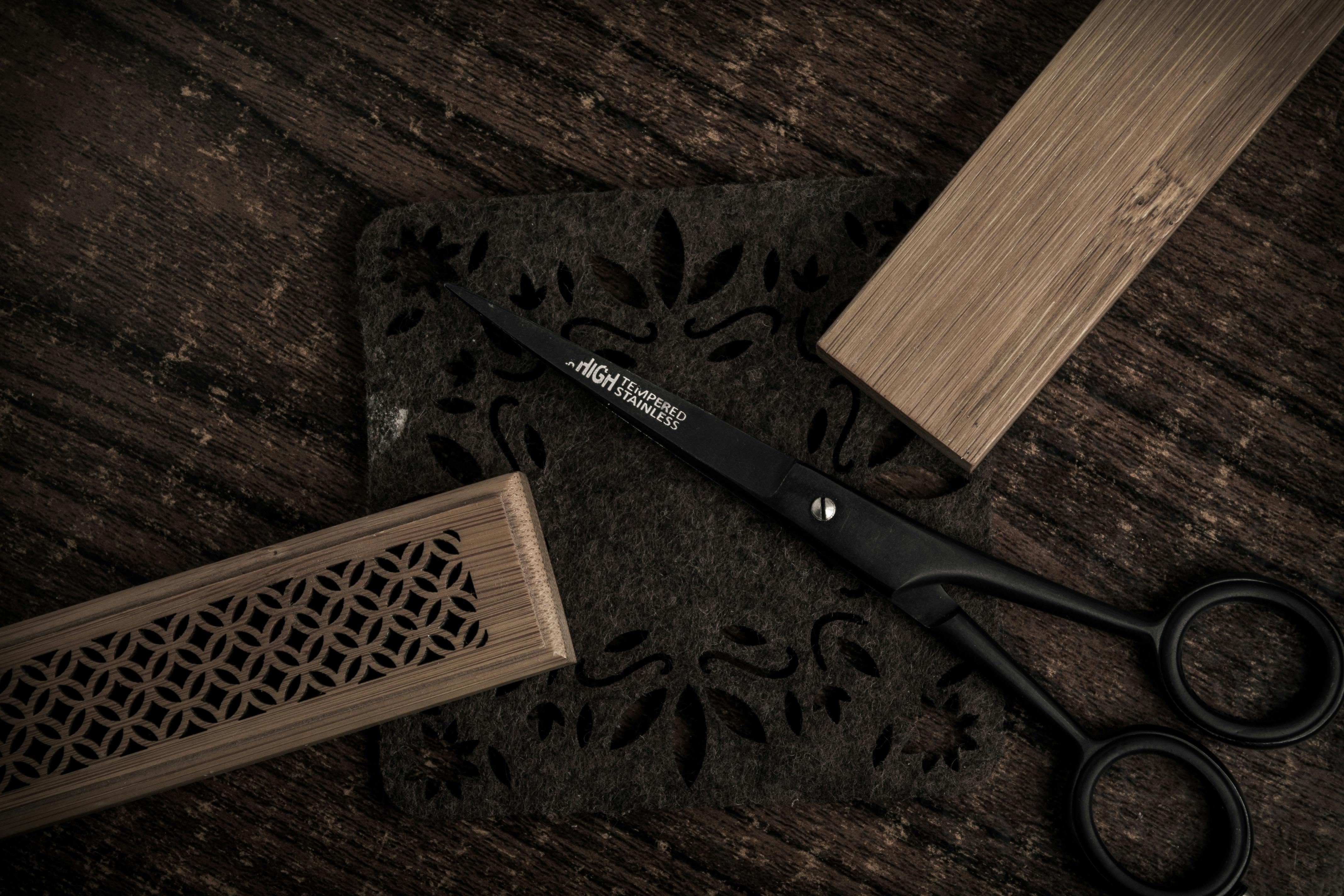A Pair of Black Scissors on Brown Wooden Surface · Free Stock Photo