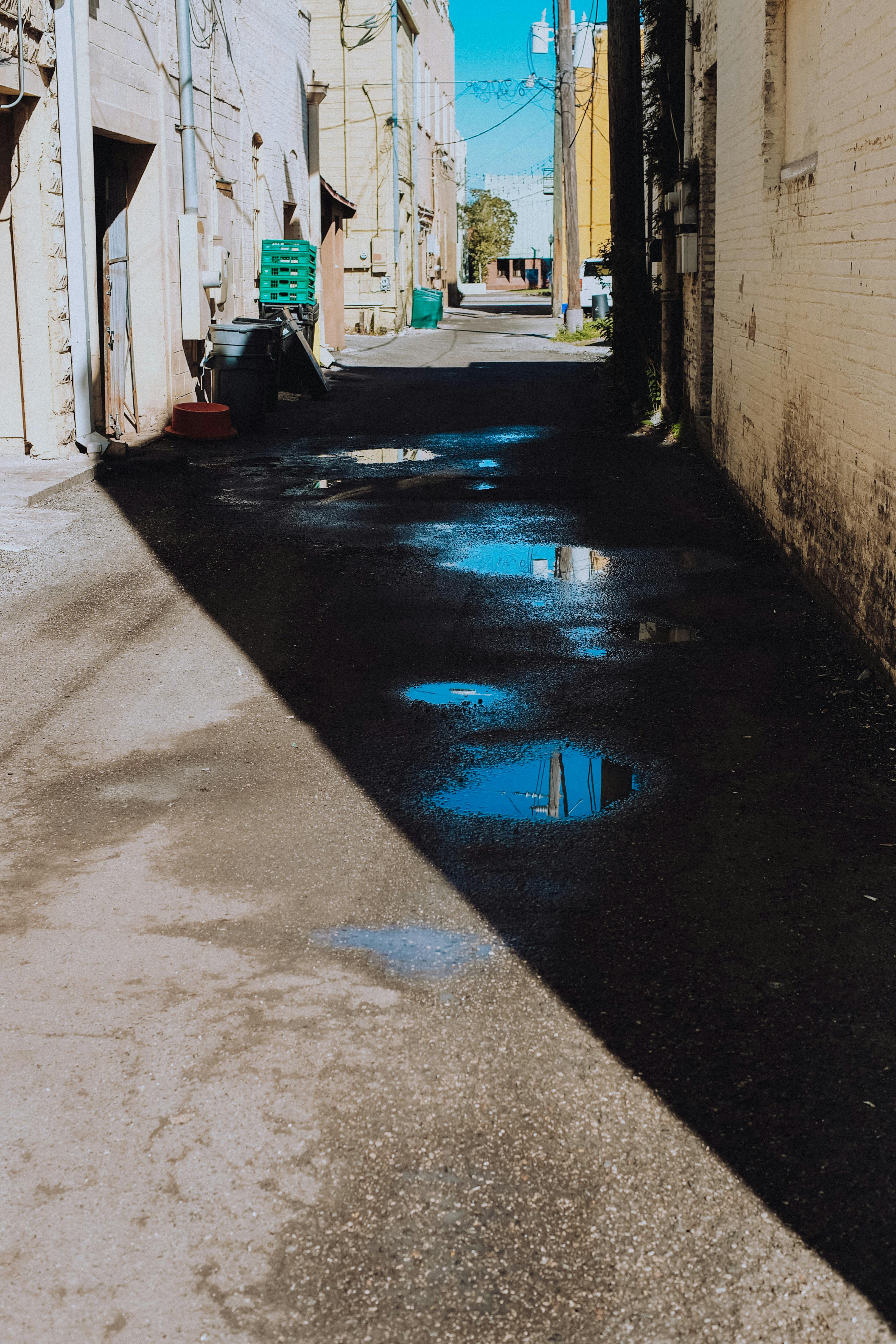 Wet Ground an a Narrow Alleyway Between Concrete Buildings · Free Stock ...
