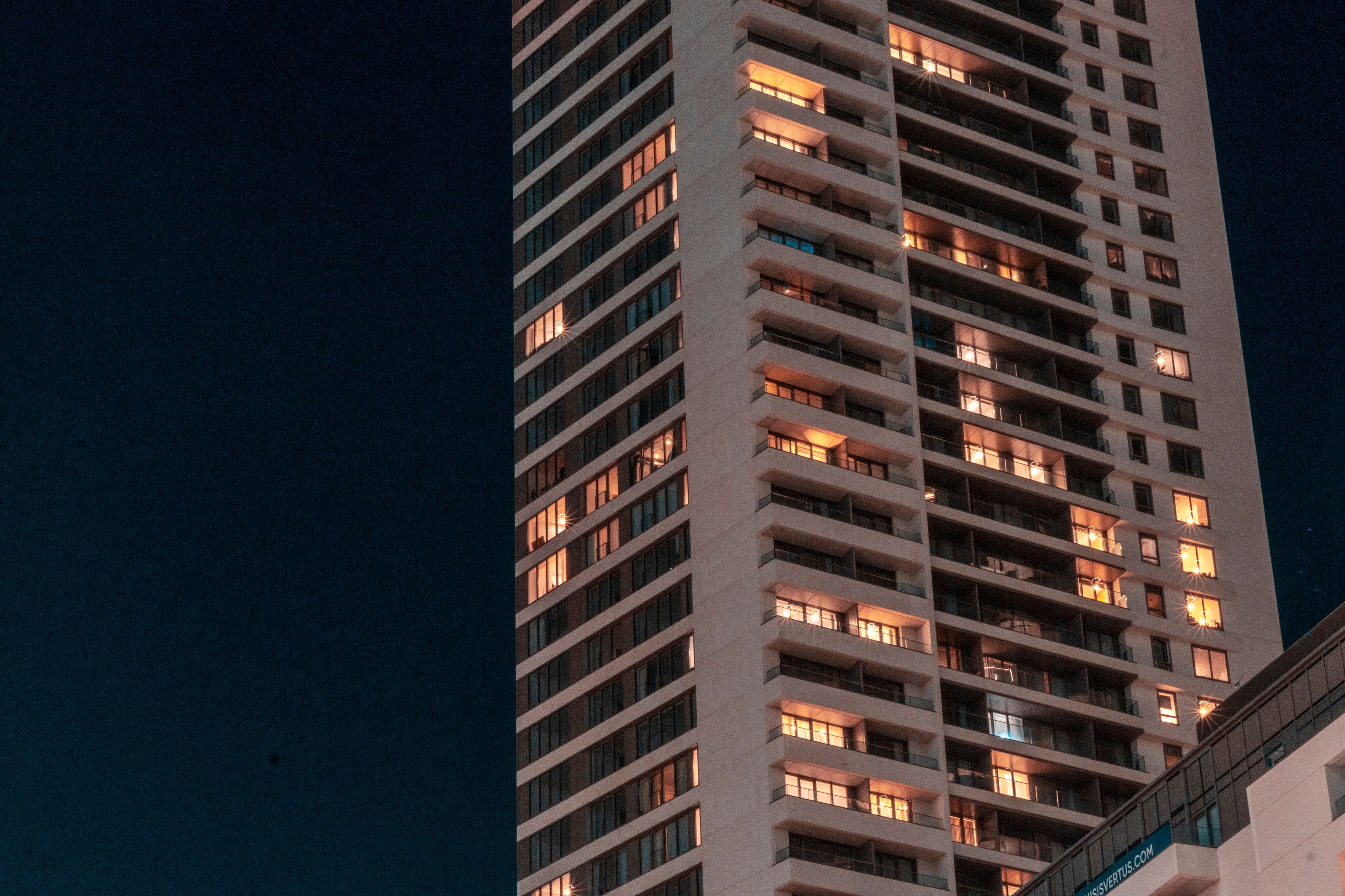 A tall building with lights on at night · Free Stock Photo