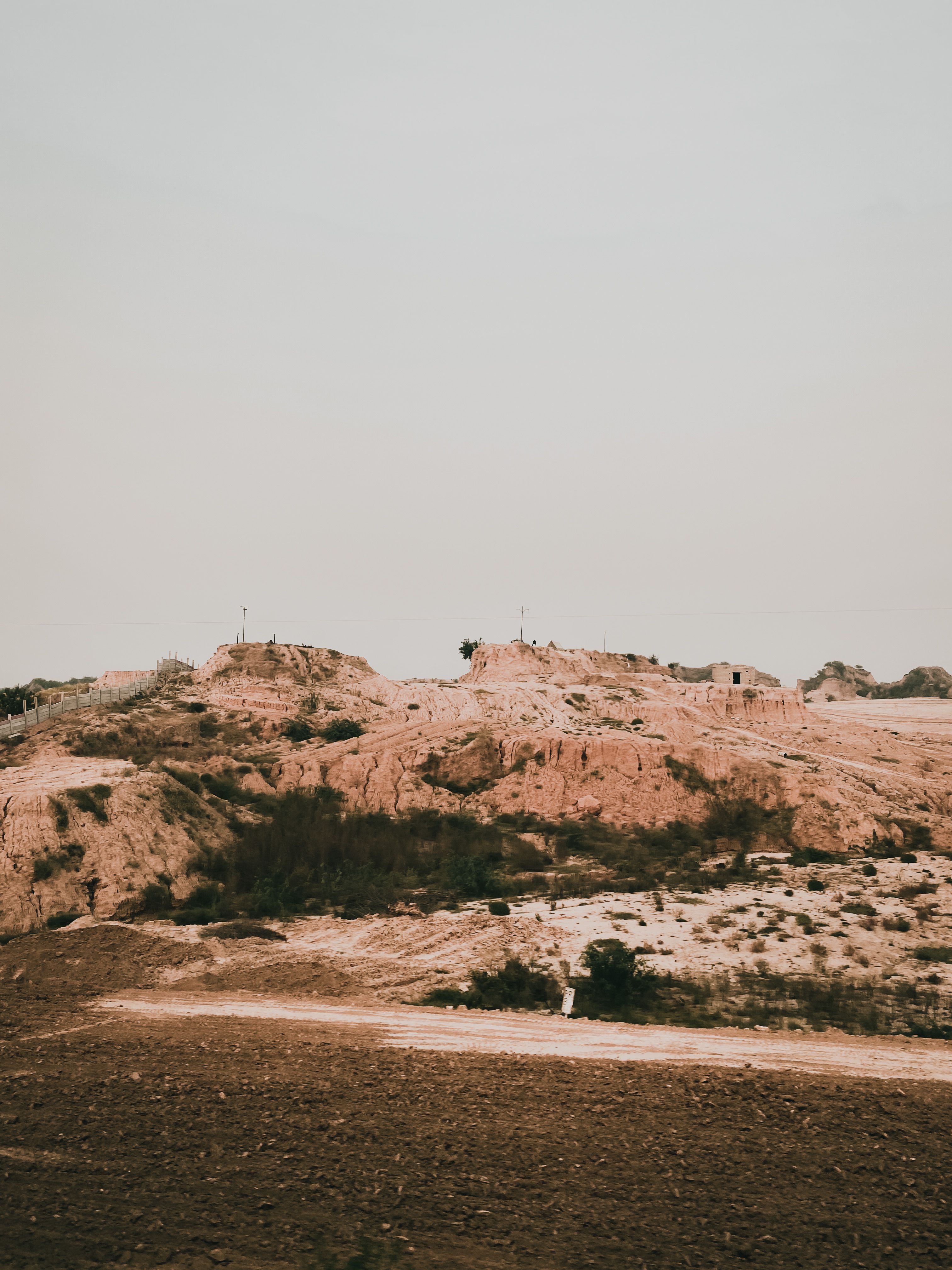 Field at the Bottom of a Sandstone Hill · Free Stock Photo