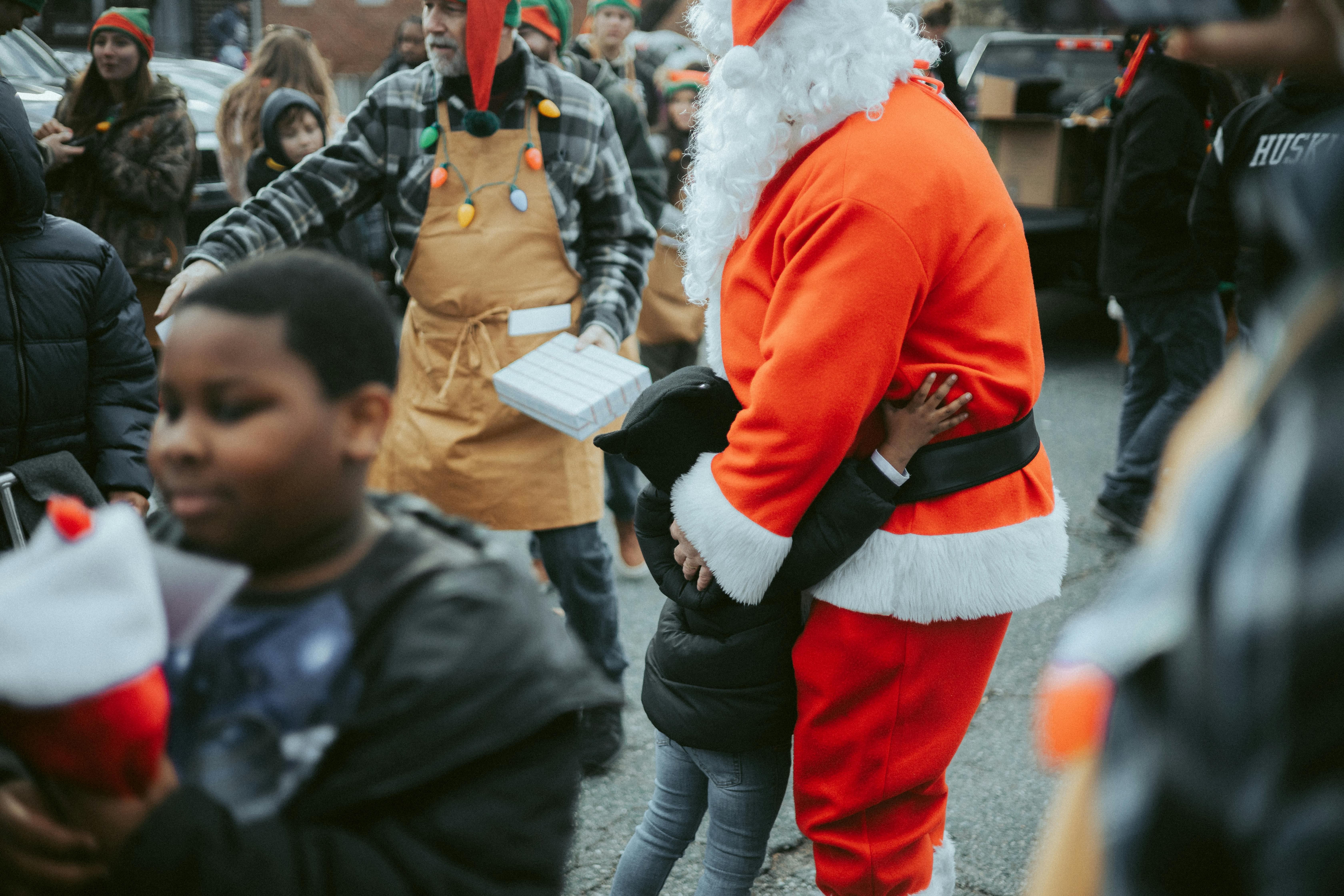 Child Hugging Santa Claus on the Street · Free Stock Photo