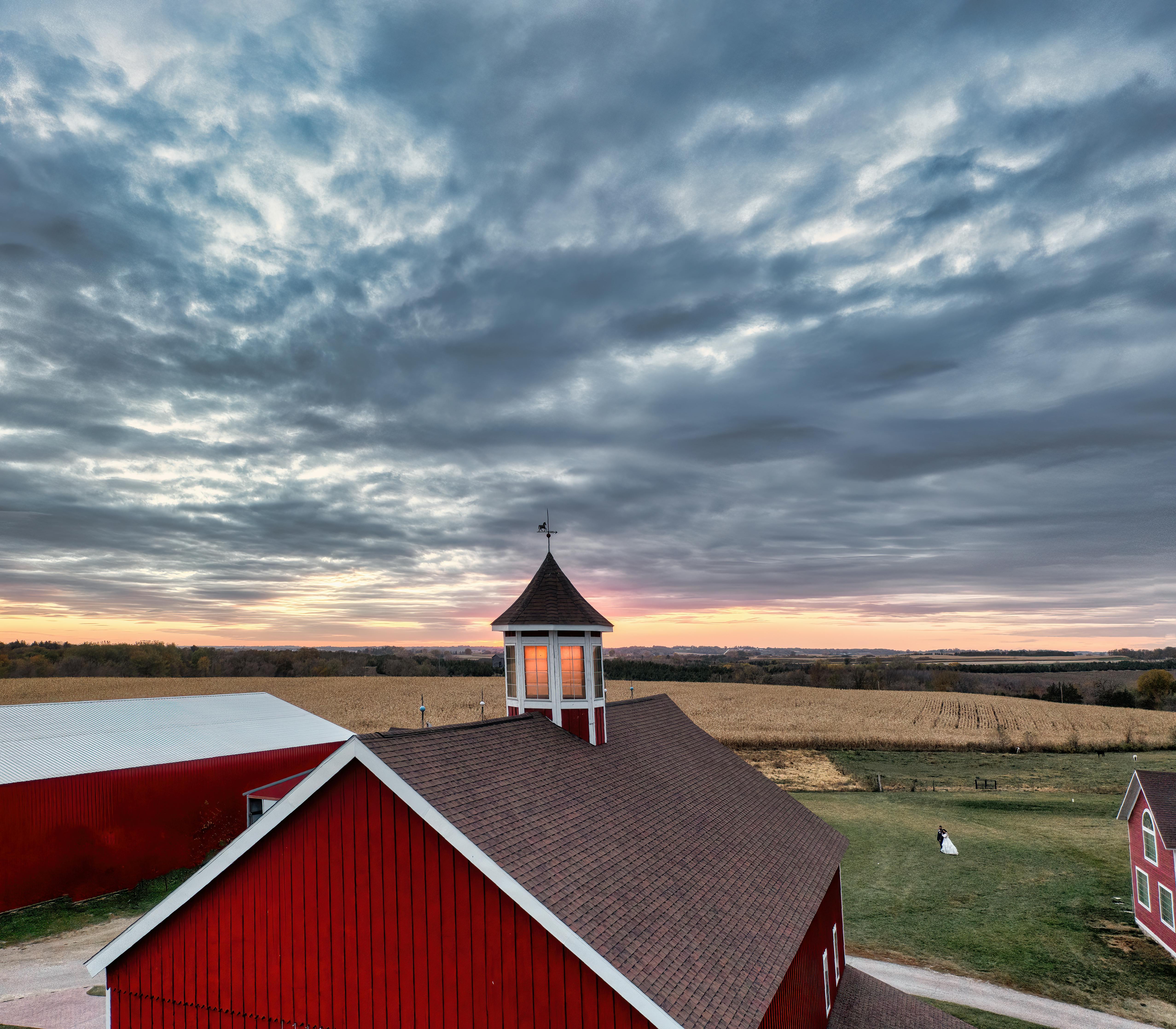 Photo of Red Farm Buildings Against a Cloudy Sky · Free Stock Photo