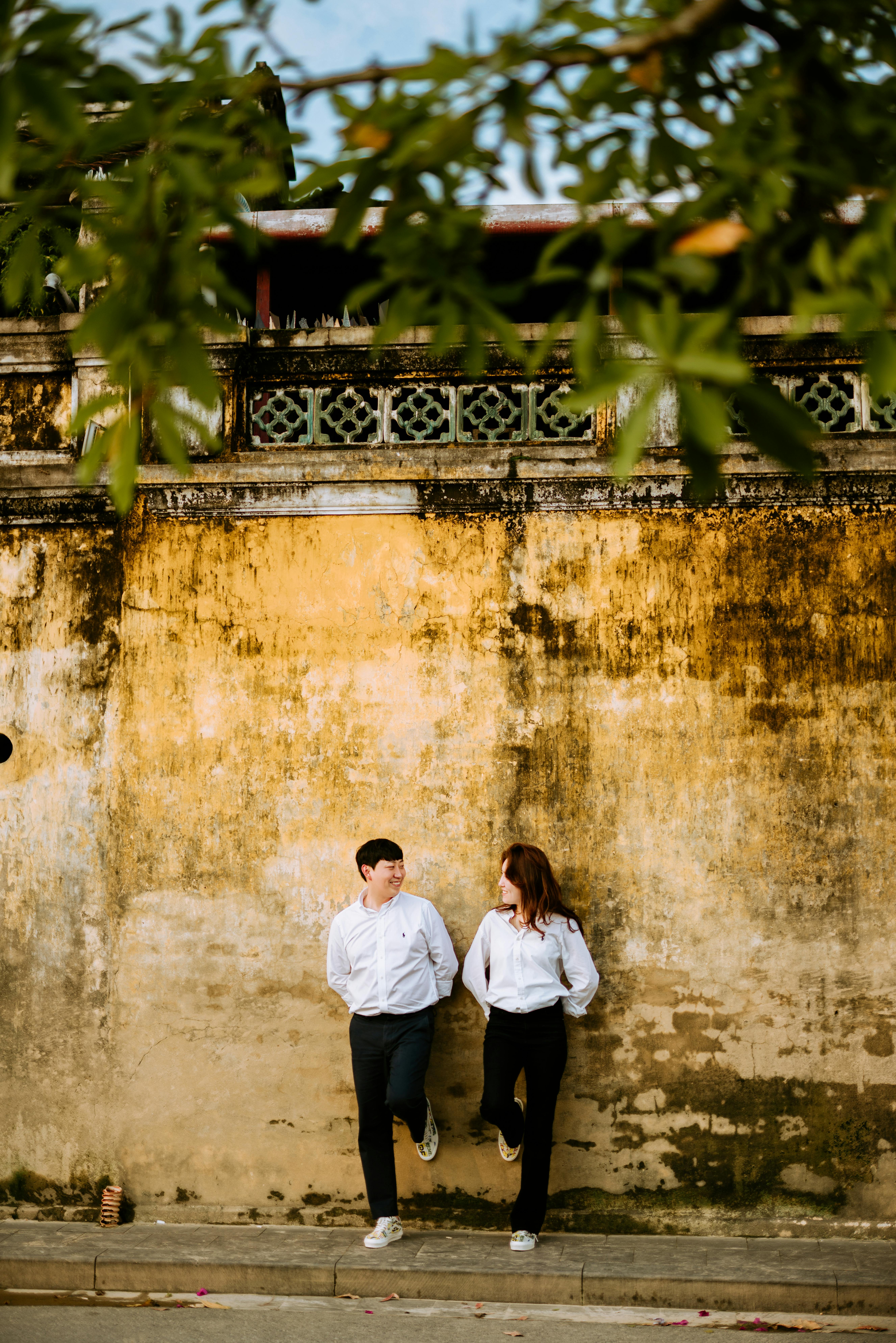 A Couple Standing by a Wall · Free Stock Photo