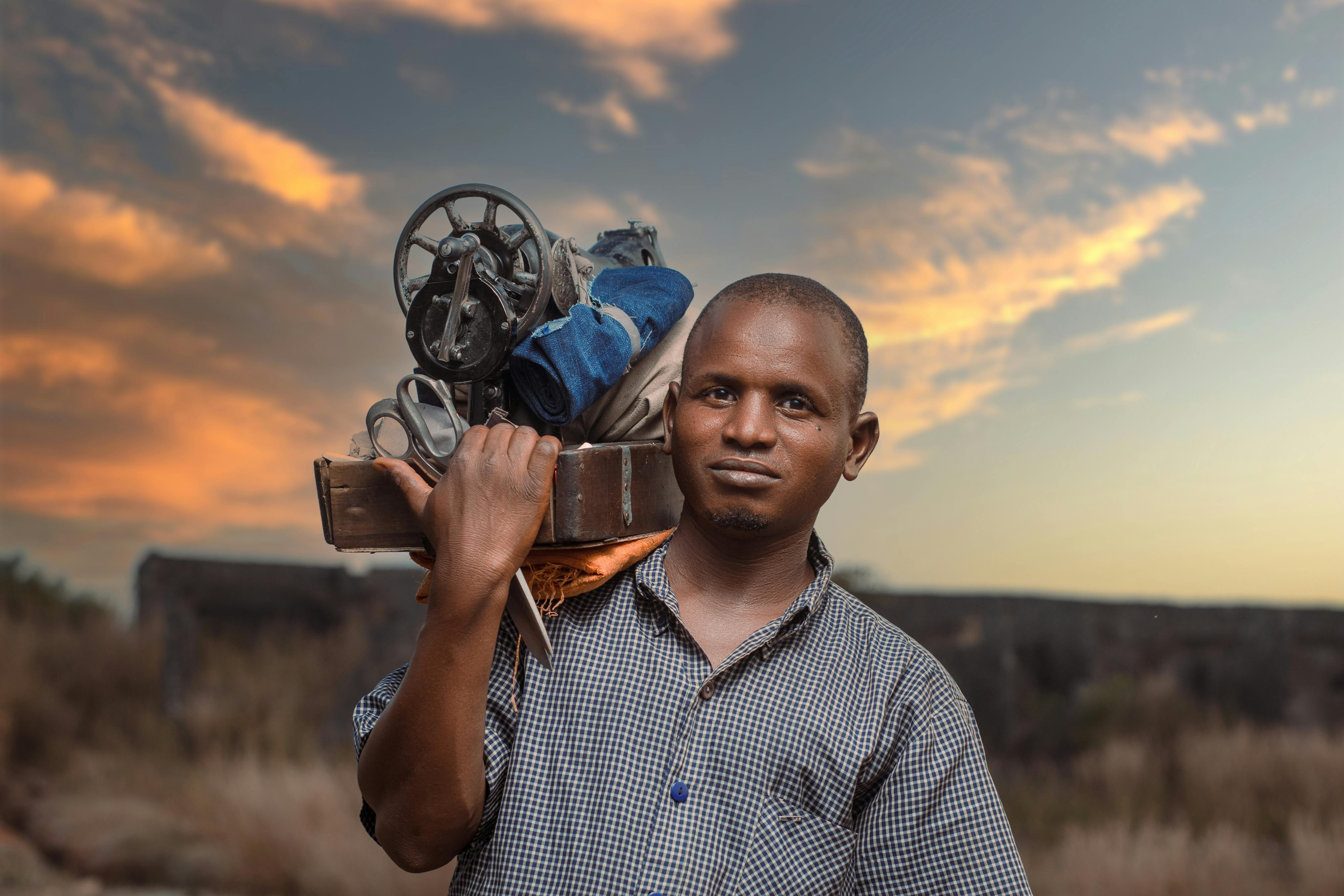 Man Carrying a Sewing Machine on his Shoulder · Free Stock Photo