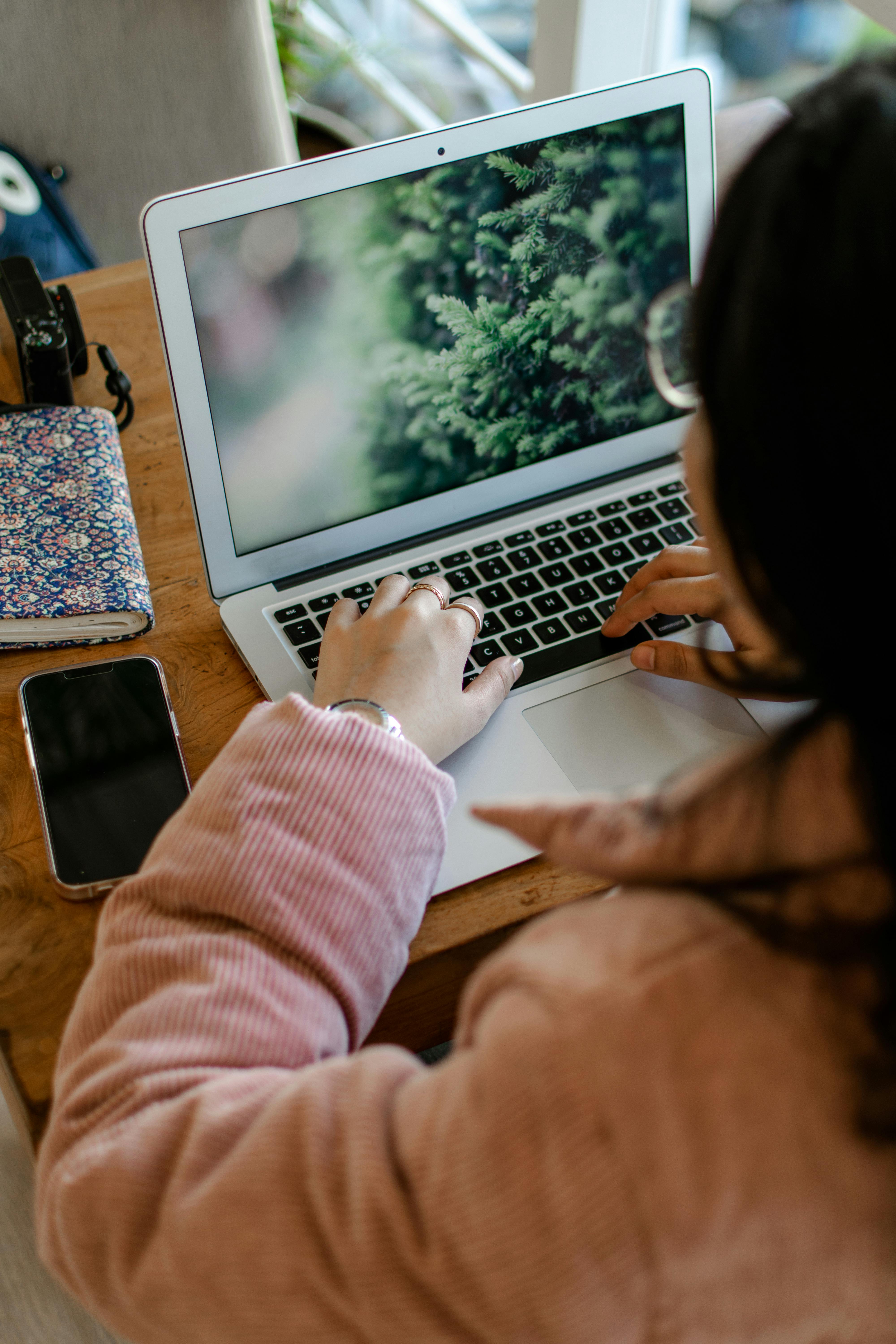 A woman is using a laptop computer with a green screen · Free Stock Photo