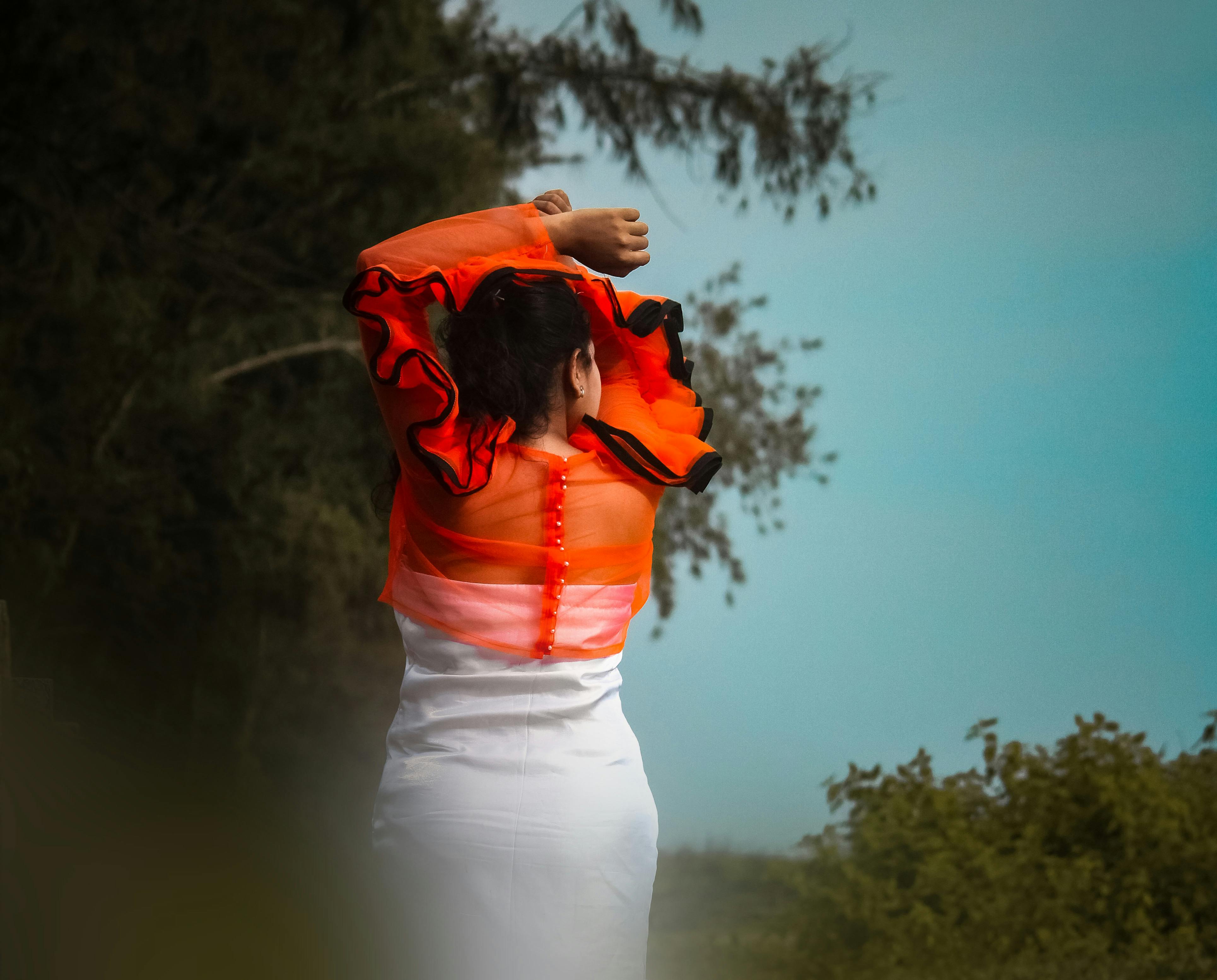 Back View of a Woman Posing with Her Arms Raised · Free Stock Photo