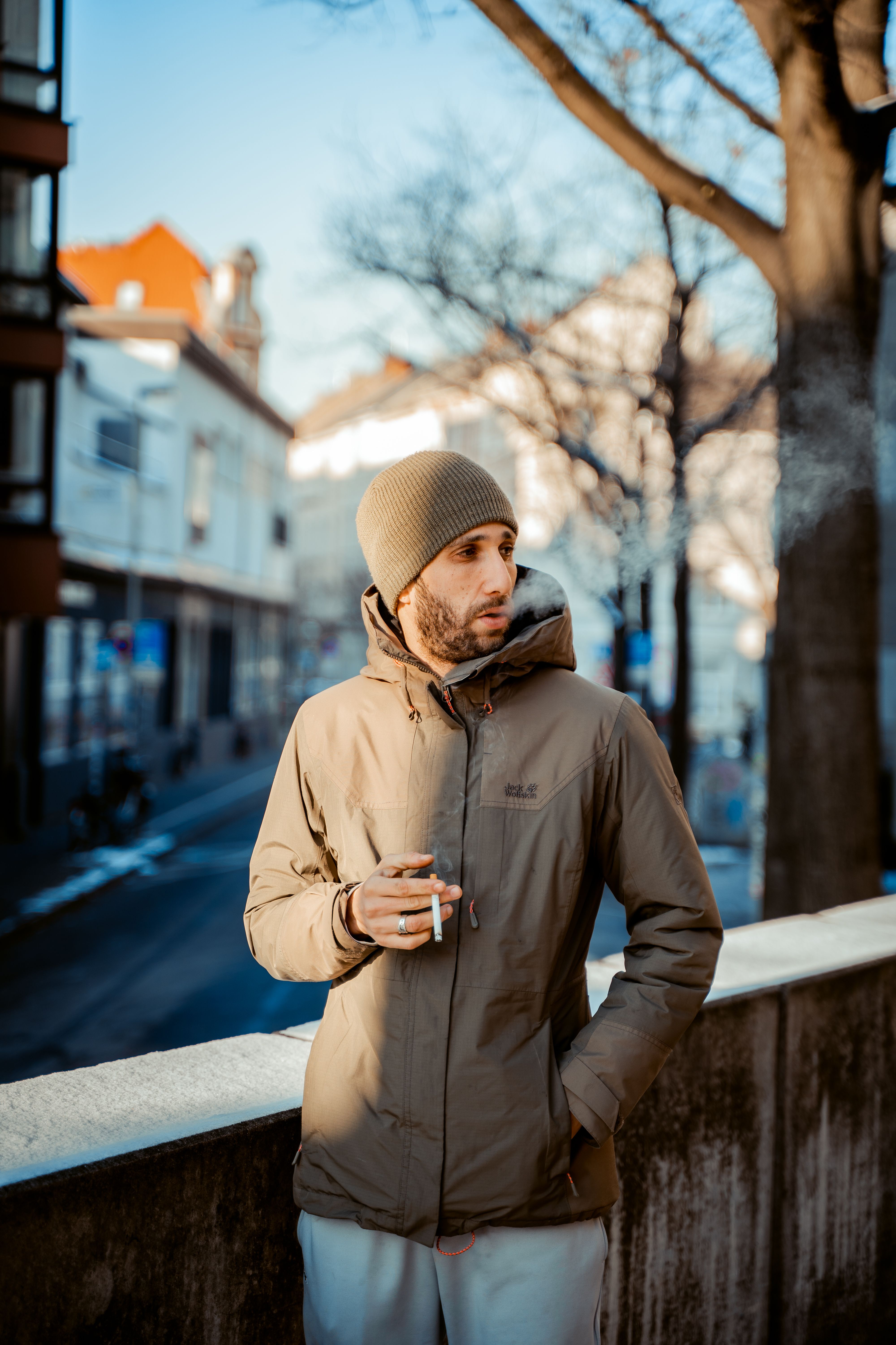 Man Smoking Cigarette Standing on Bridge above Street · Free Stock Photo