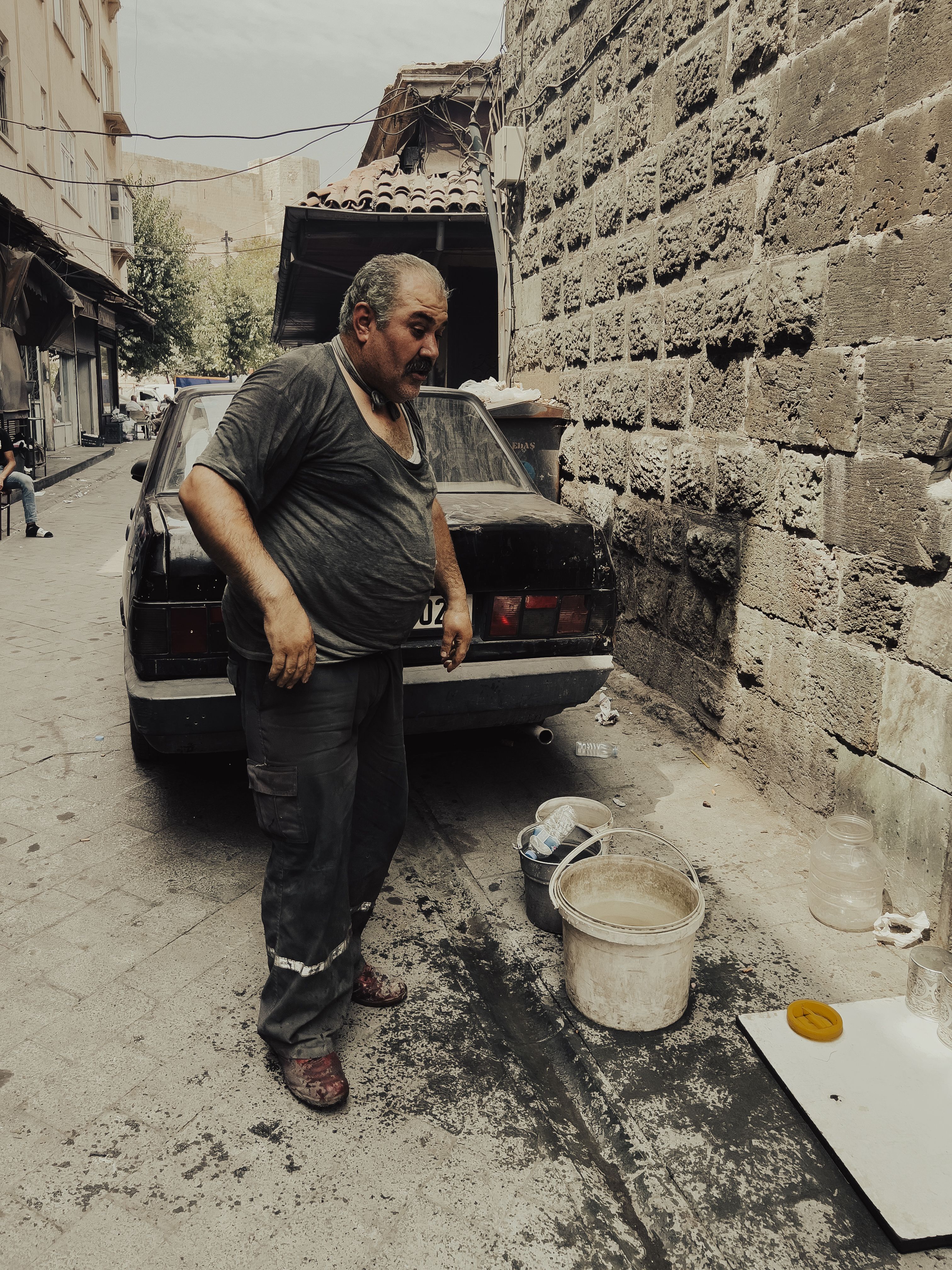 Man Standing on a Street with Buckets · Free Stock Photo