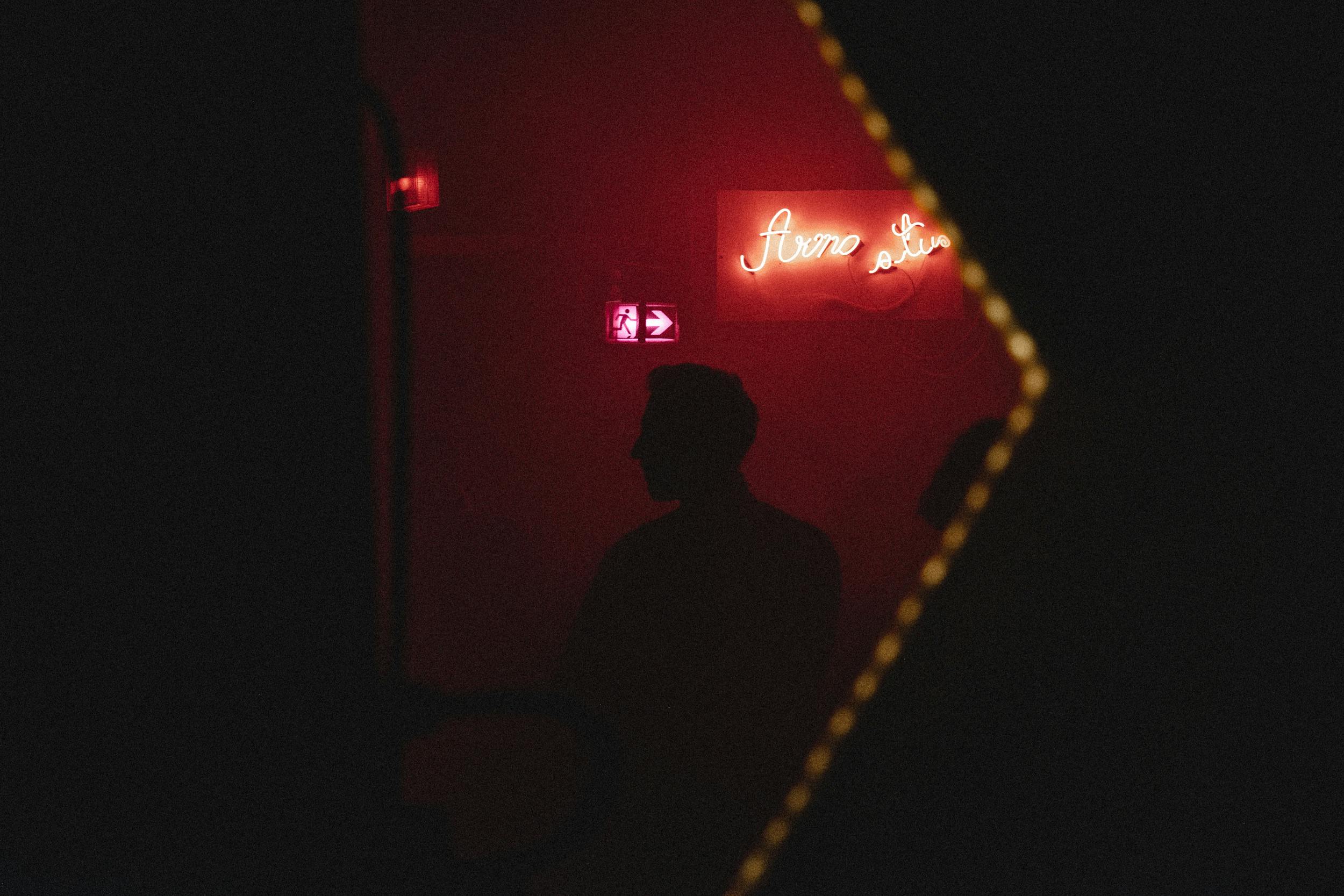 A Person Standing Beside the Neon Signage · Free Stock Photo