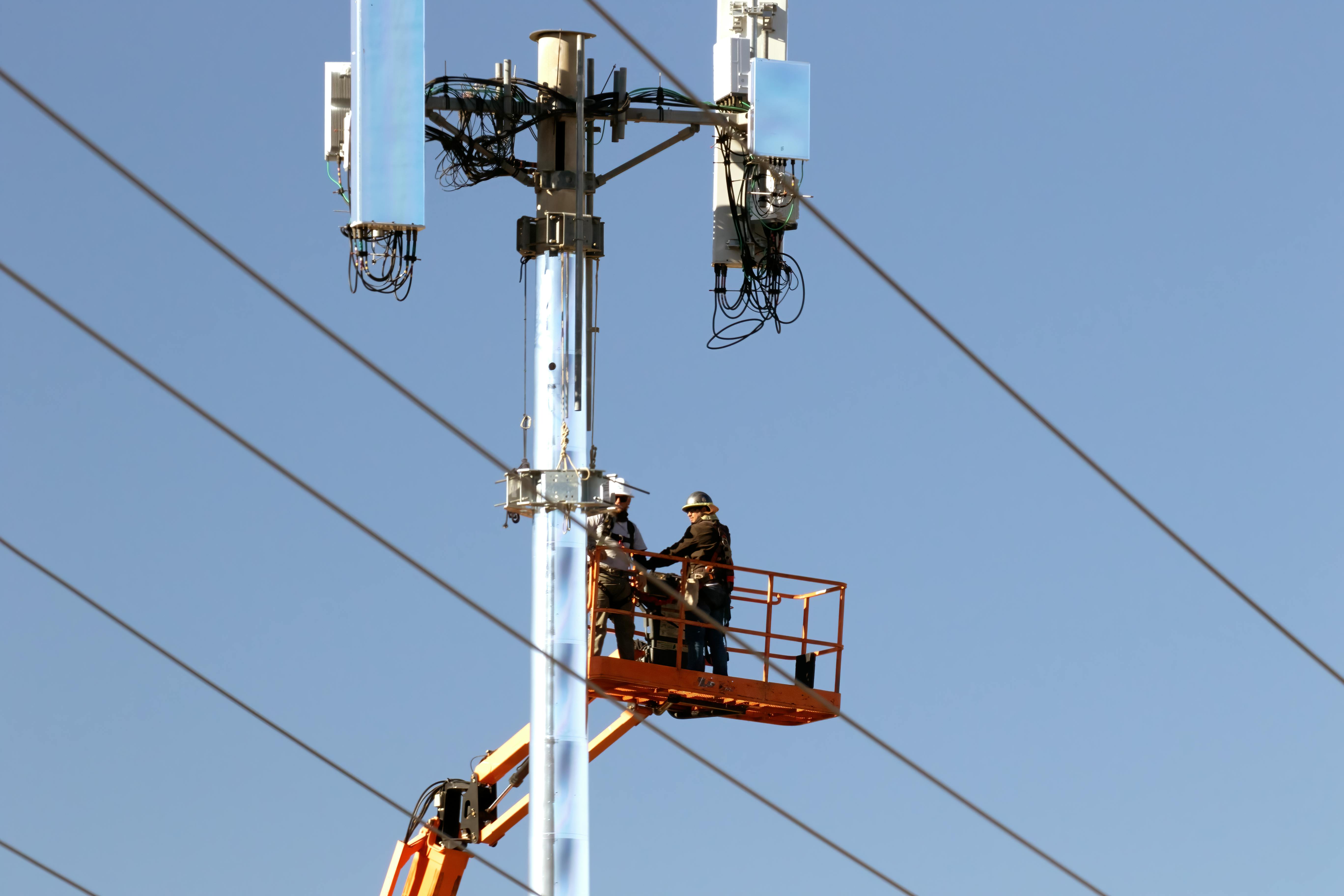 Two Workers Beside a Telephone Pole · Free Stock Photo